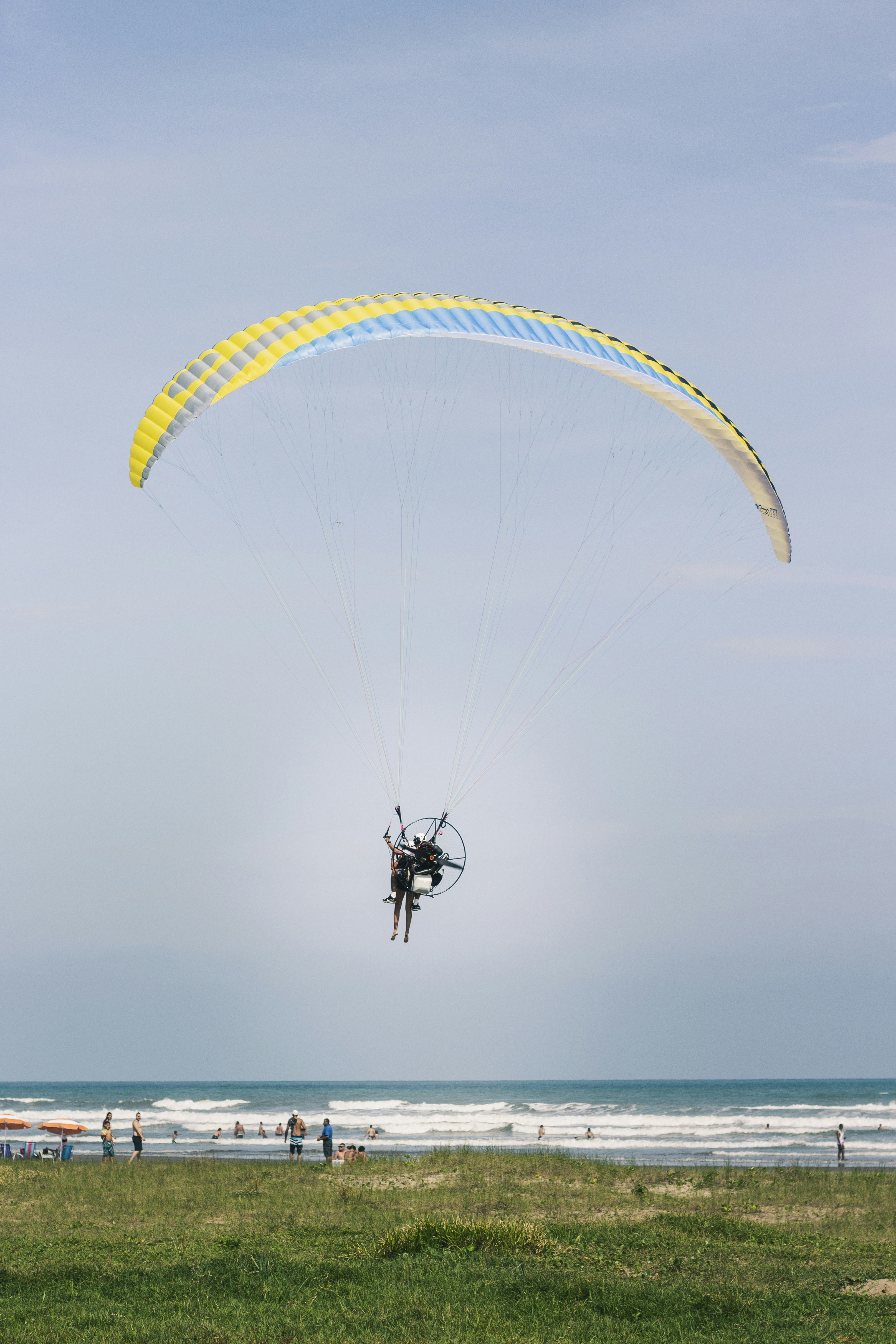 a parasailer in the air over a beach
