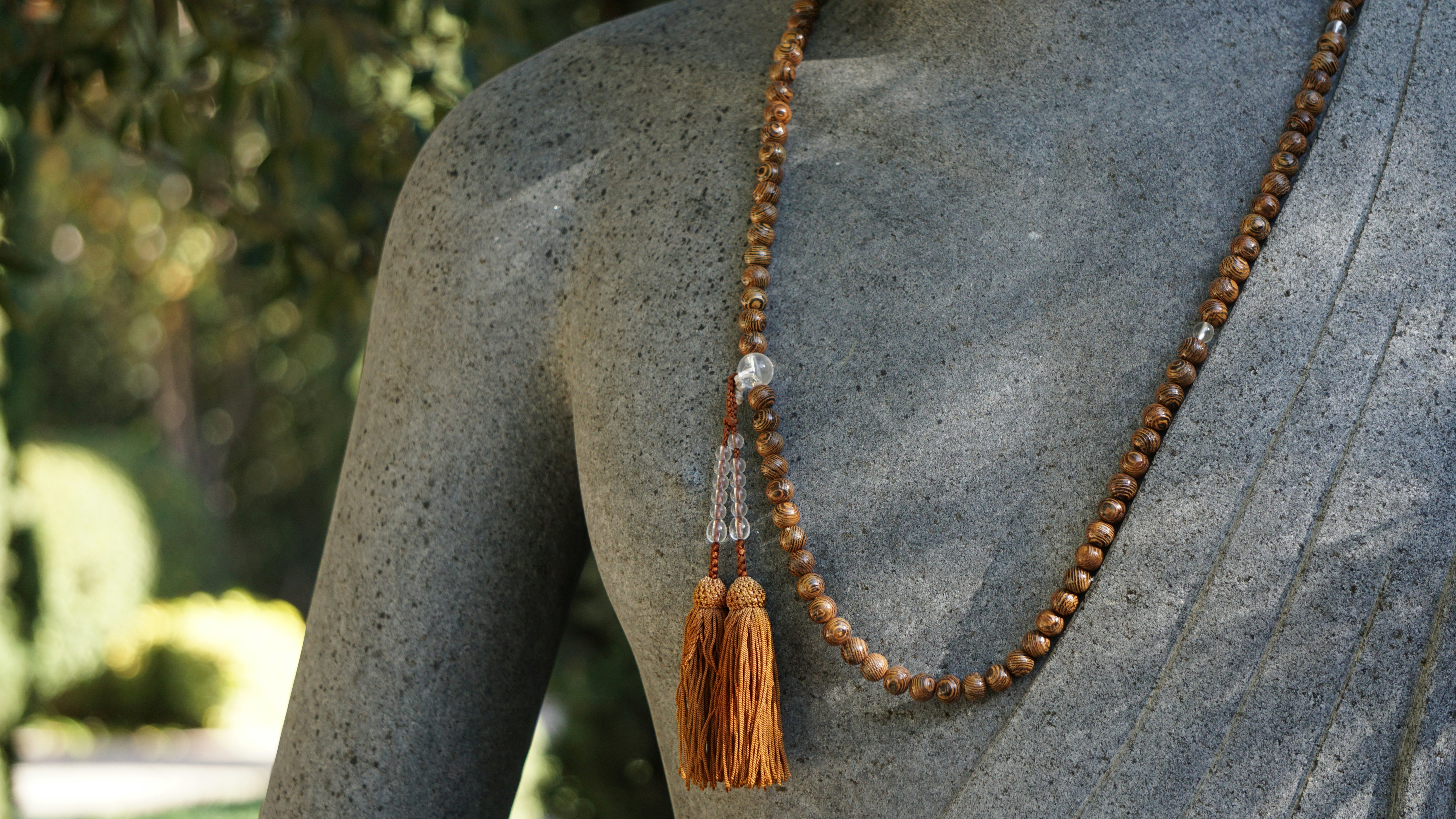 Beaded Tassel Draped Across a Weathered Stone Figure