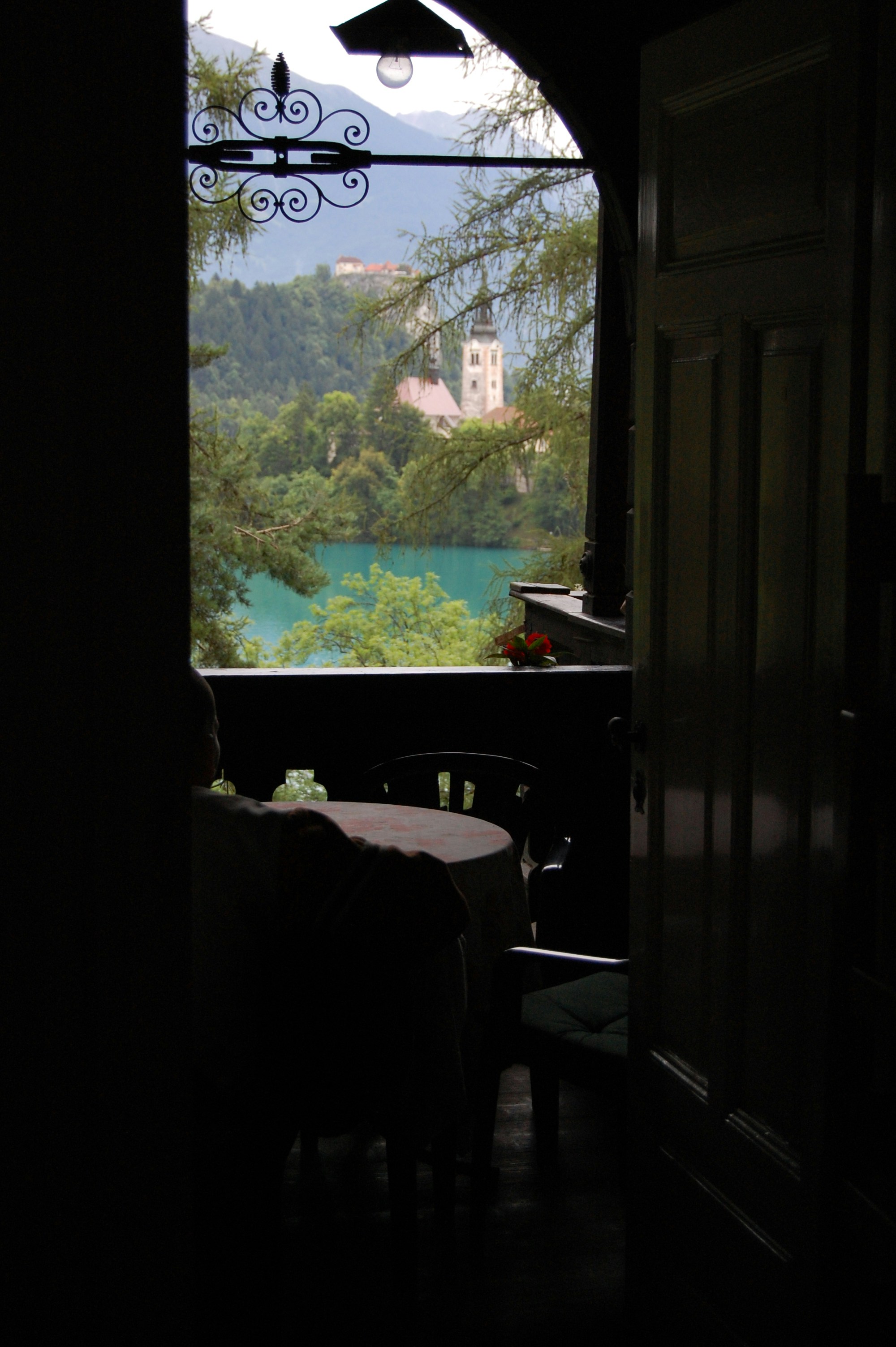 Framed Vista: Turquoise Lake and Tower Beyond a Shadowed Doorway