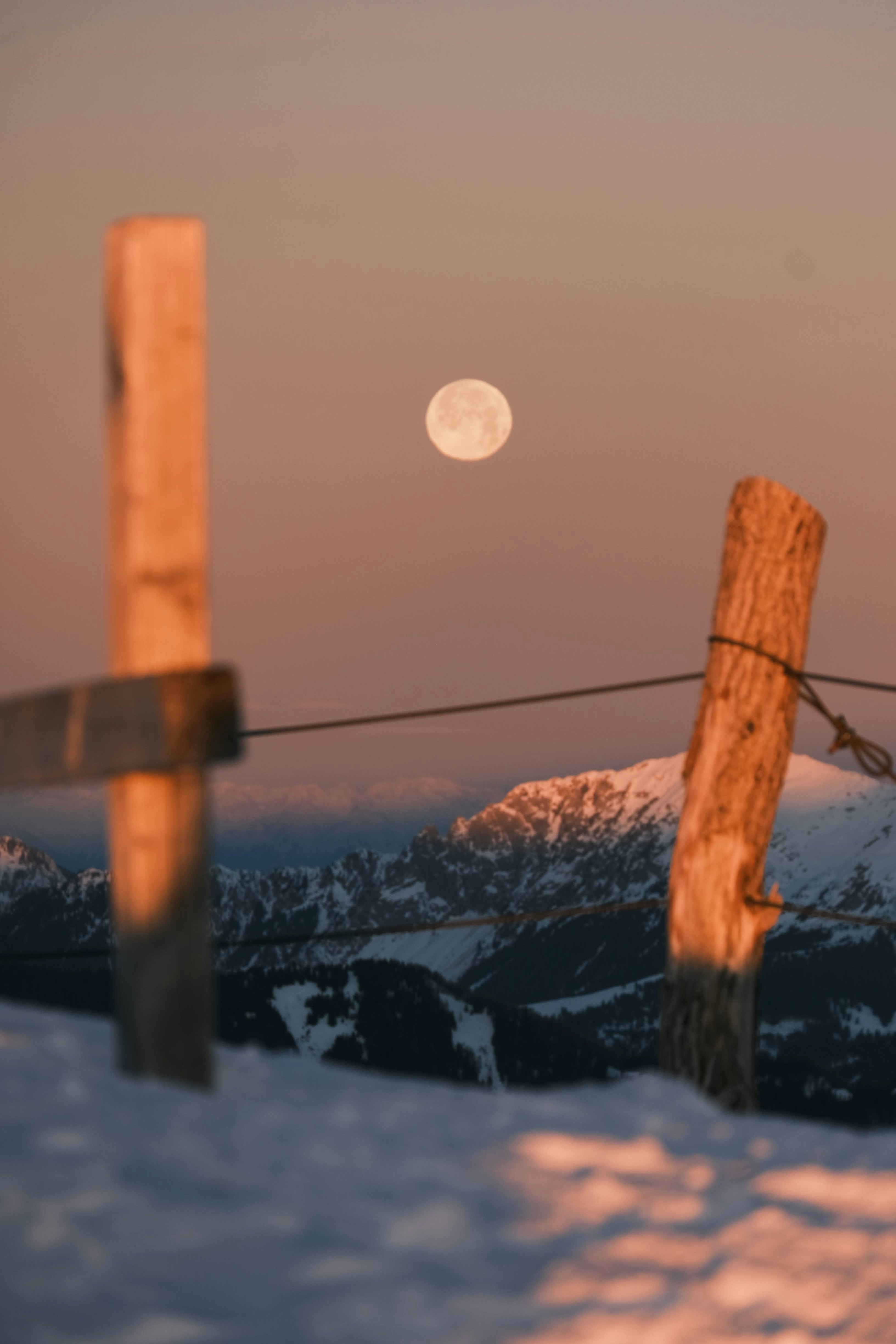 The moon is setting over a snowy mountain range photo – Free Ambrož pod ...