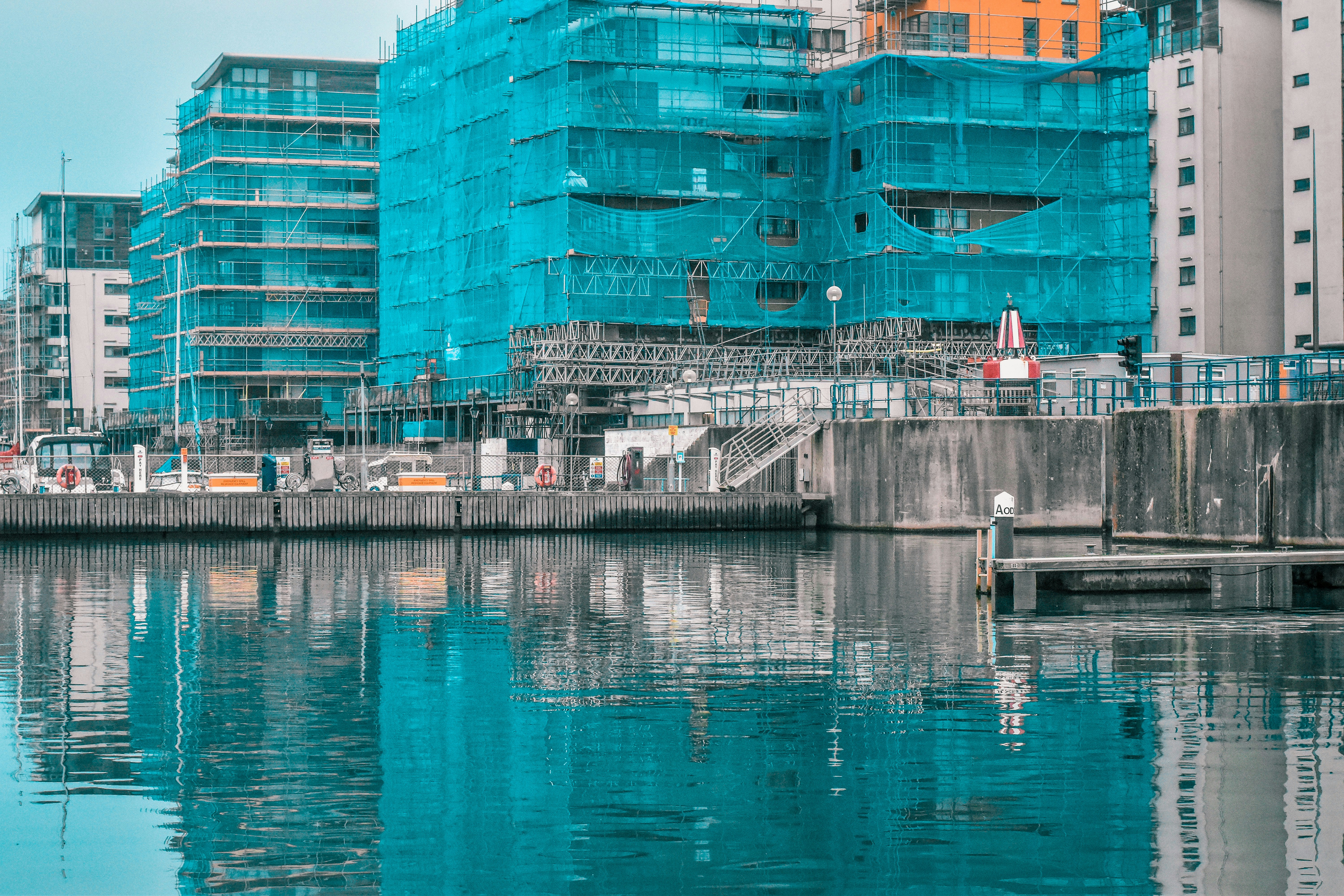 Blue-sheathed construction by the harbor