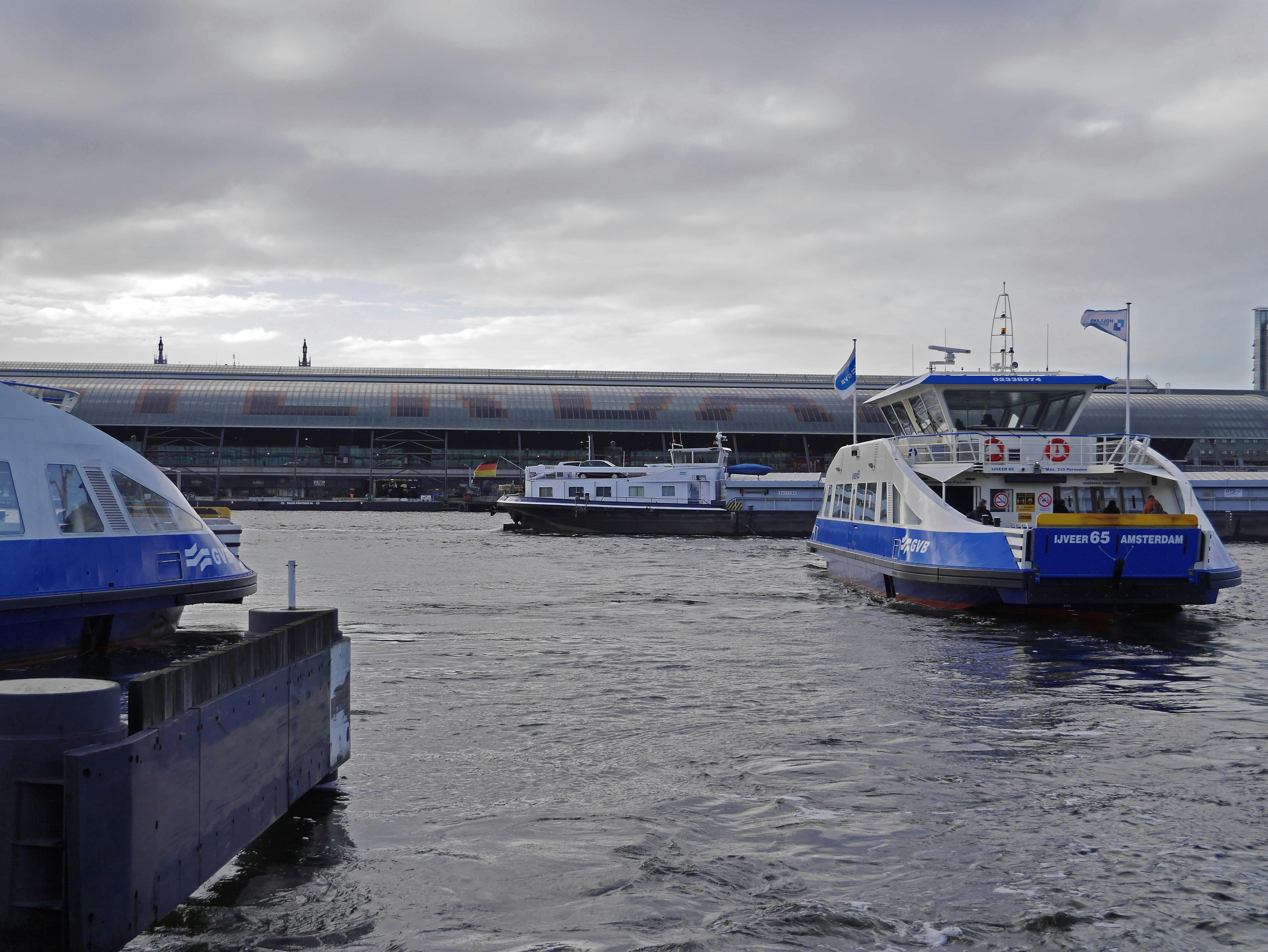 Ferries navigating the tranquil waters of a bustling harbor, with a modern terminal in the background. Flags flutter gently in the breeze.