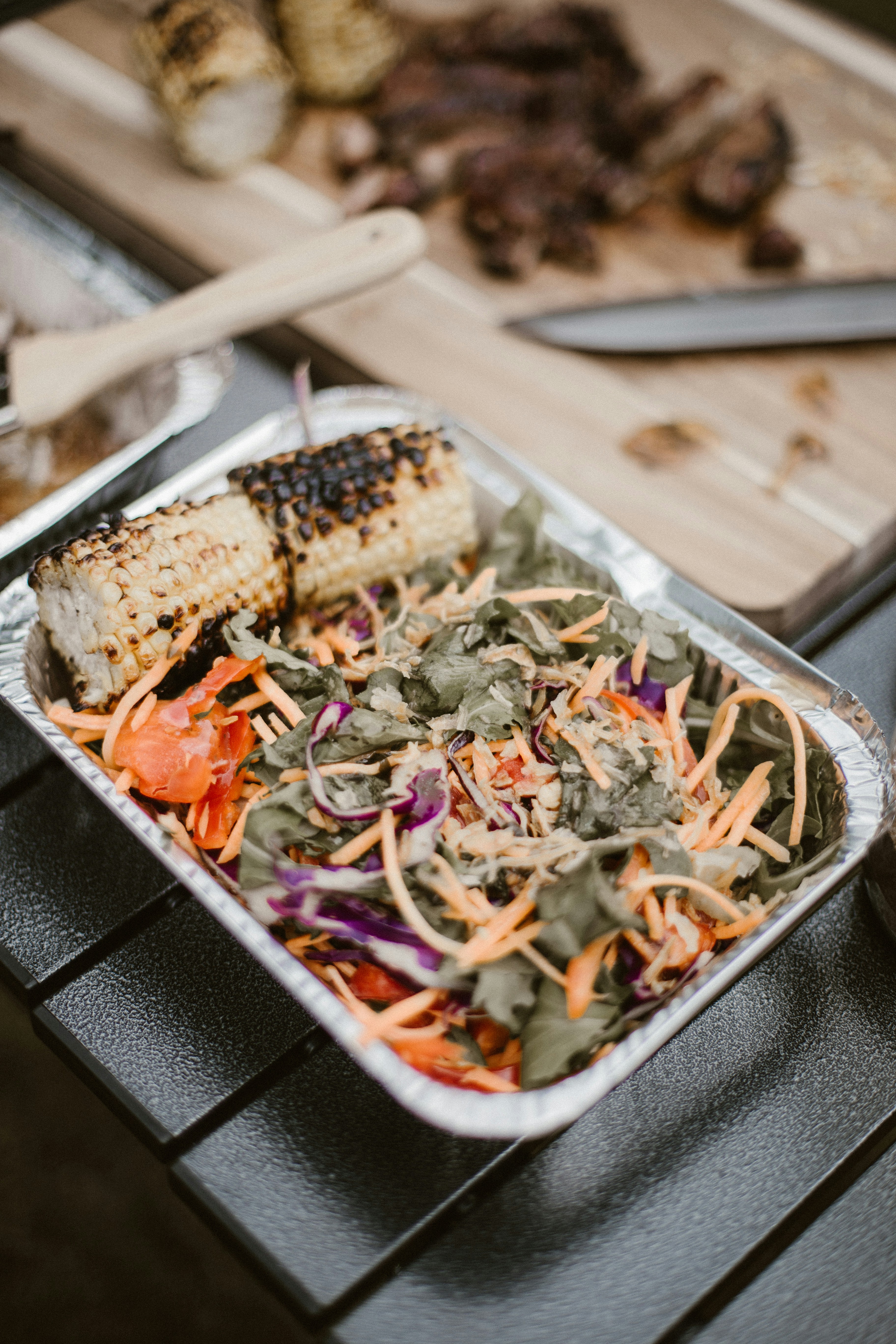 Smoked corn and herb salad in a glossy aluminum tray
