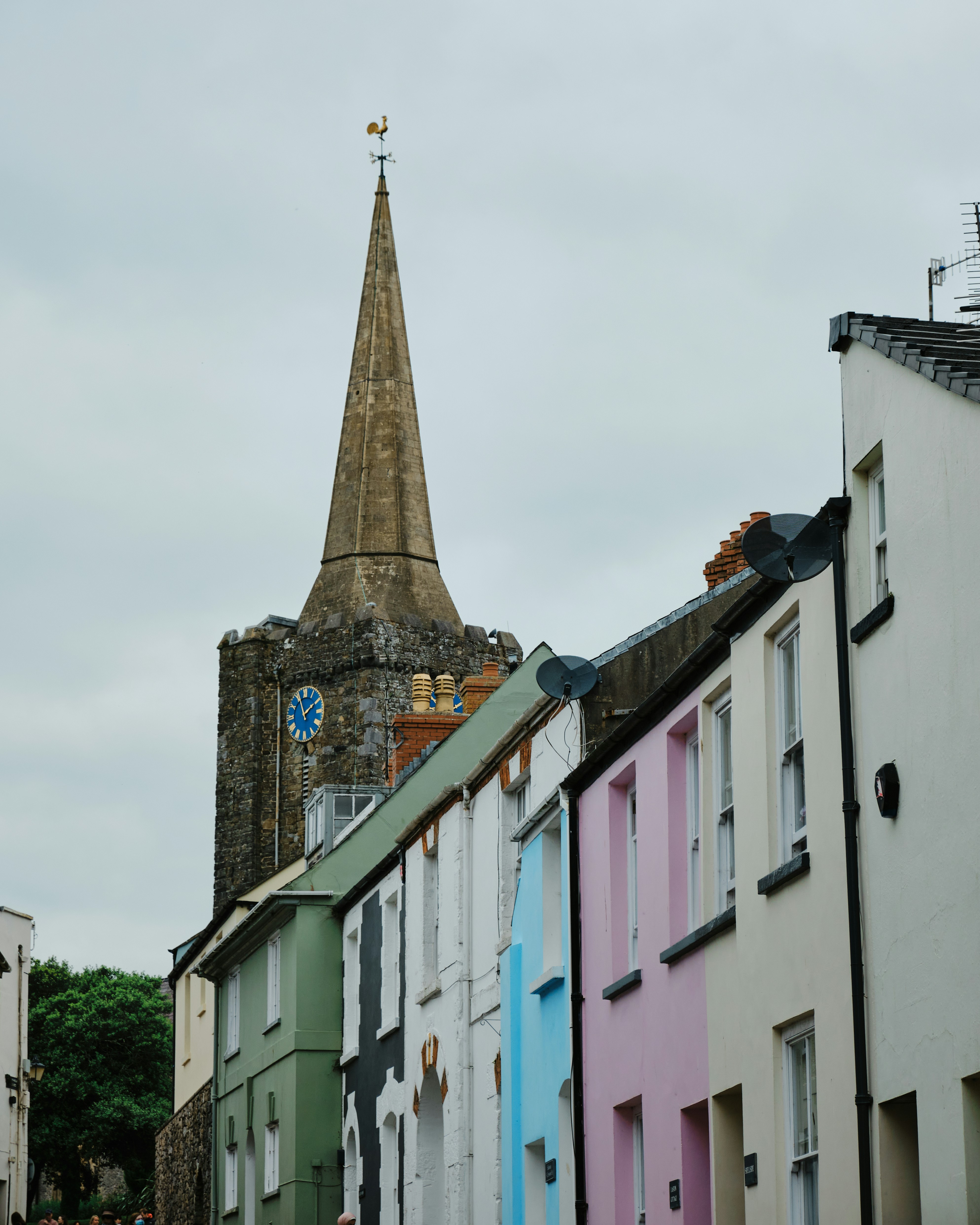 A row of multi - colored buildings with a steeple in the background ...