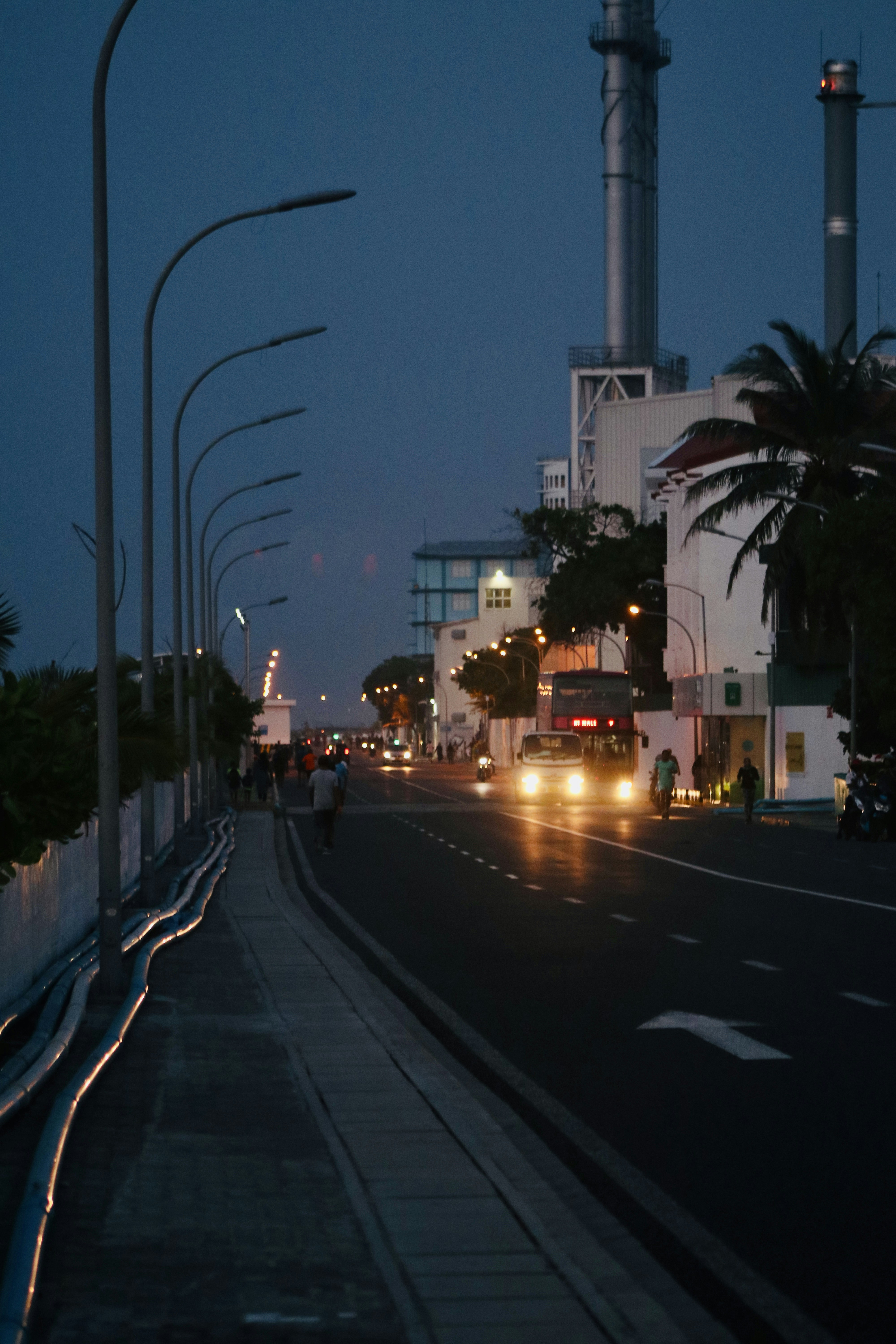 Blue-Hour Corridor: Headlights Threading the Industrial Night