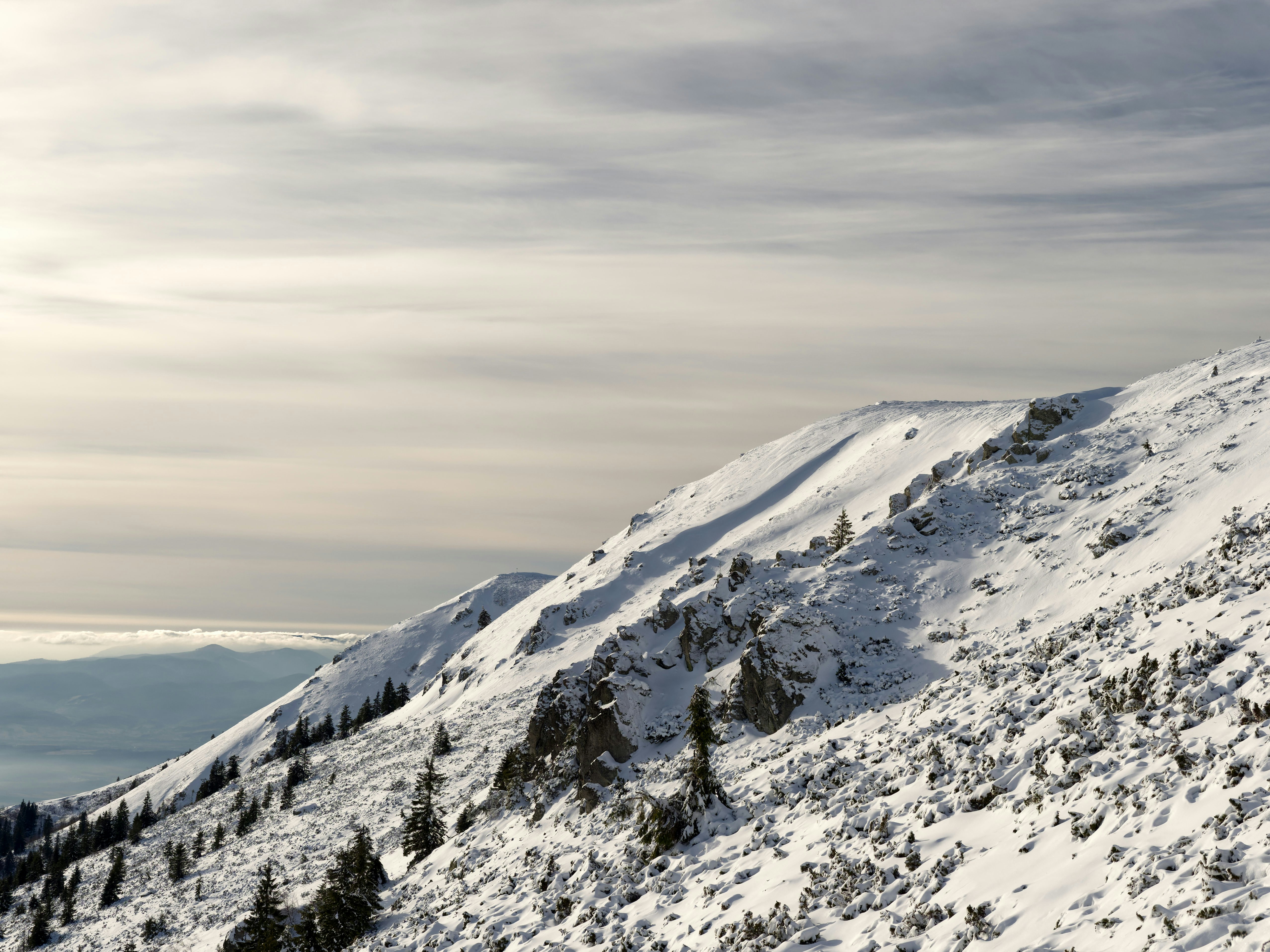 a man riding skis down the side of a snow covered slope
