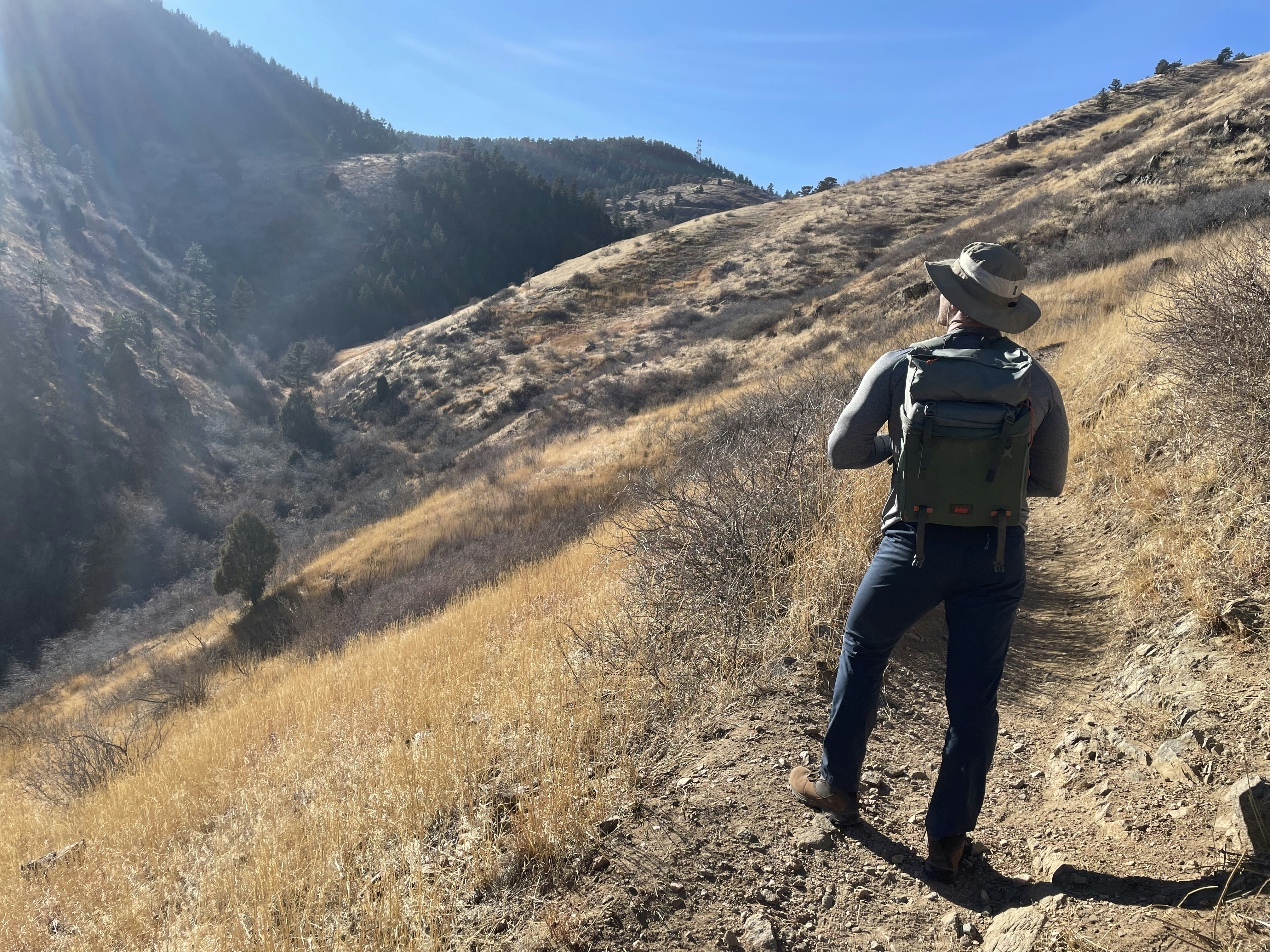 A man with a backpack is walking up a hill photo – Free Portrait Image ...