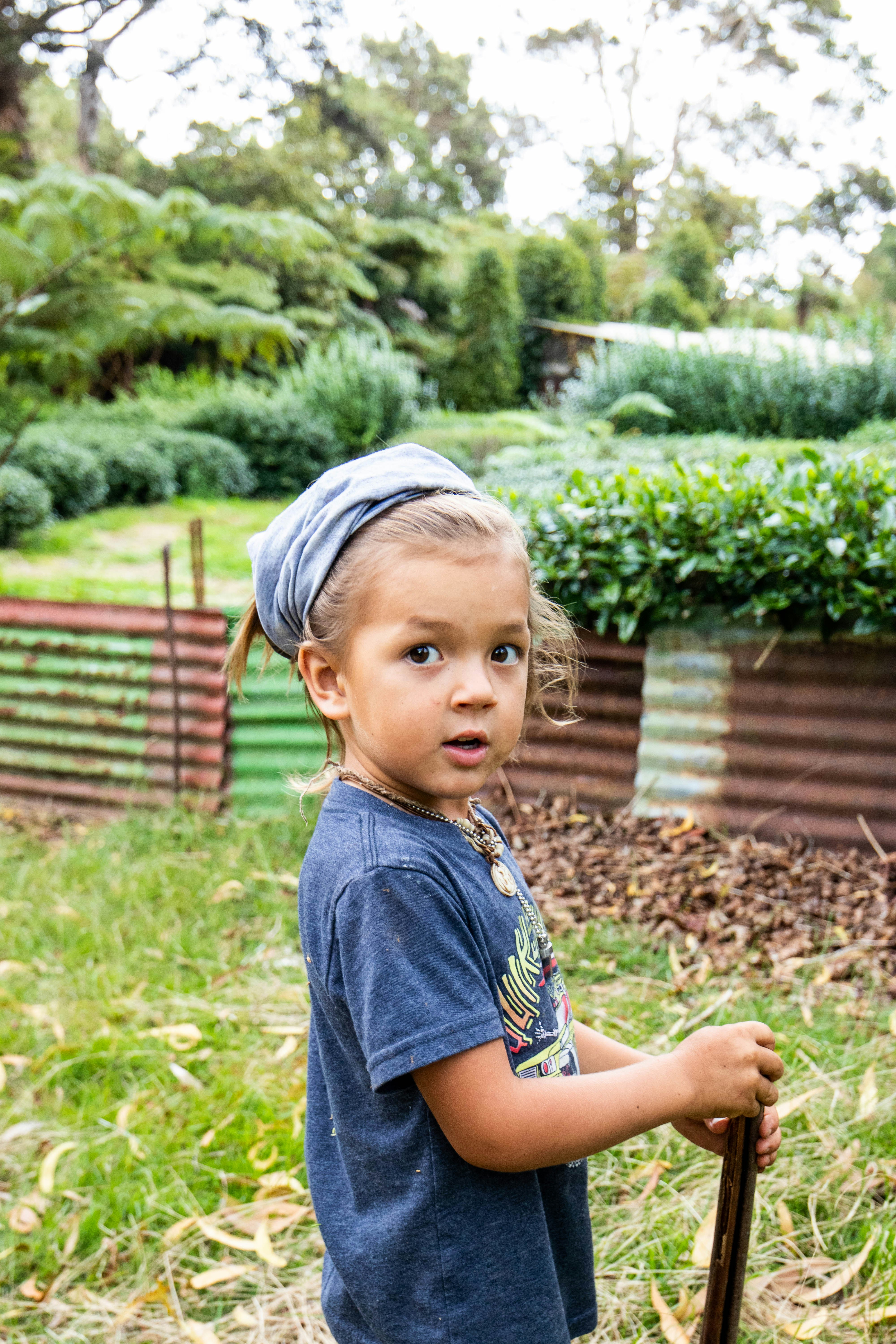 a little girl holding a baseball bat in a field