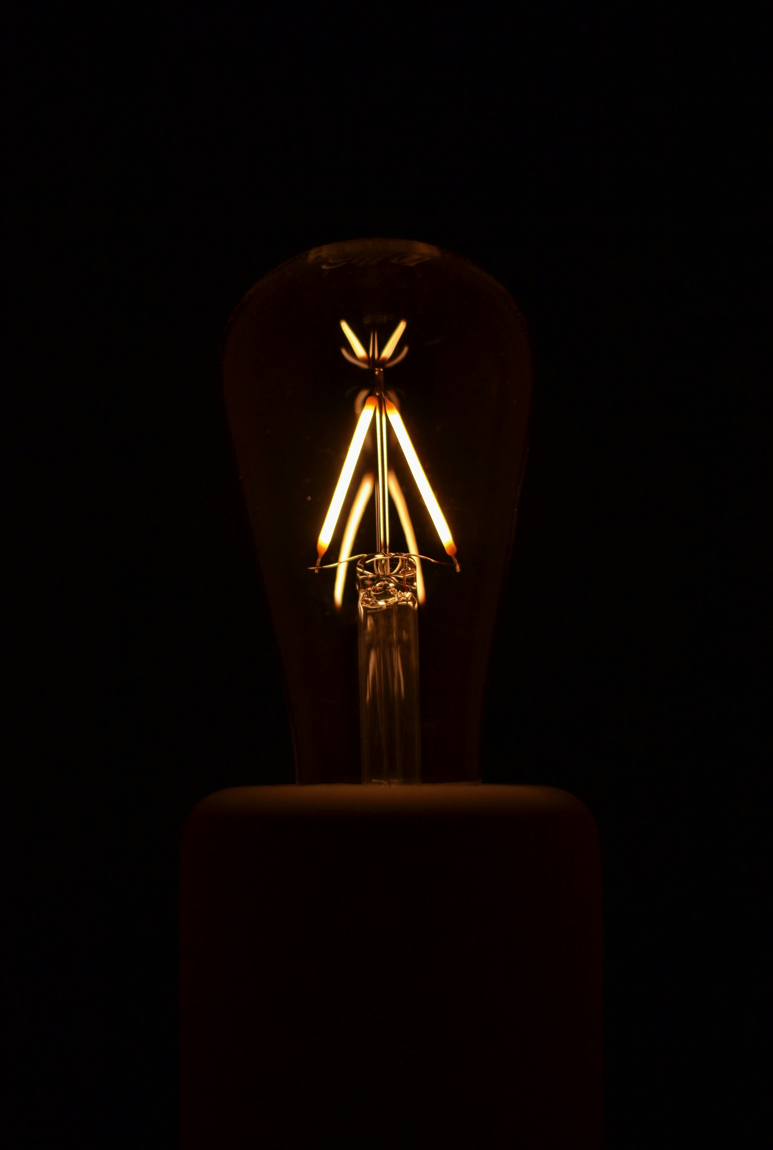 Midnight Filament: a lone tungsten glow within a glass bulb