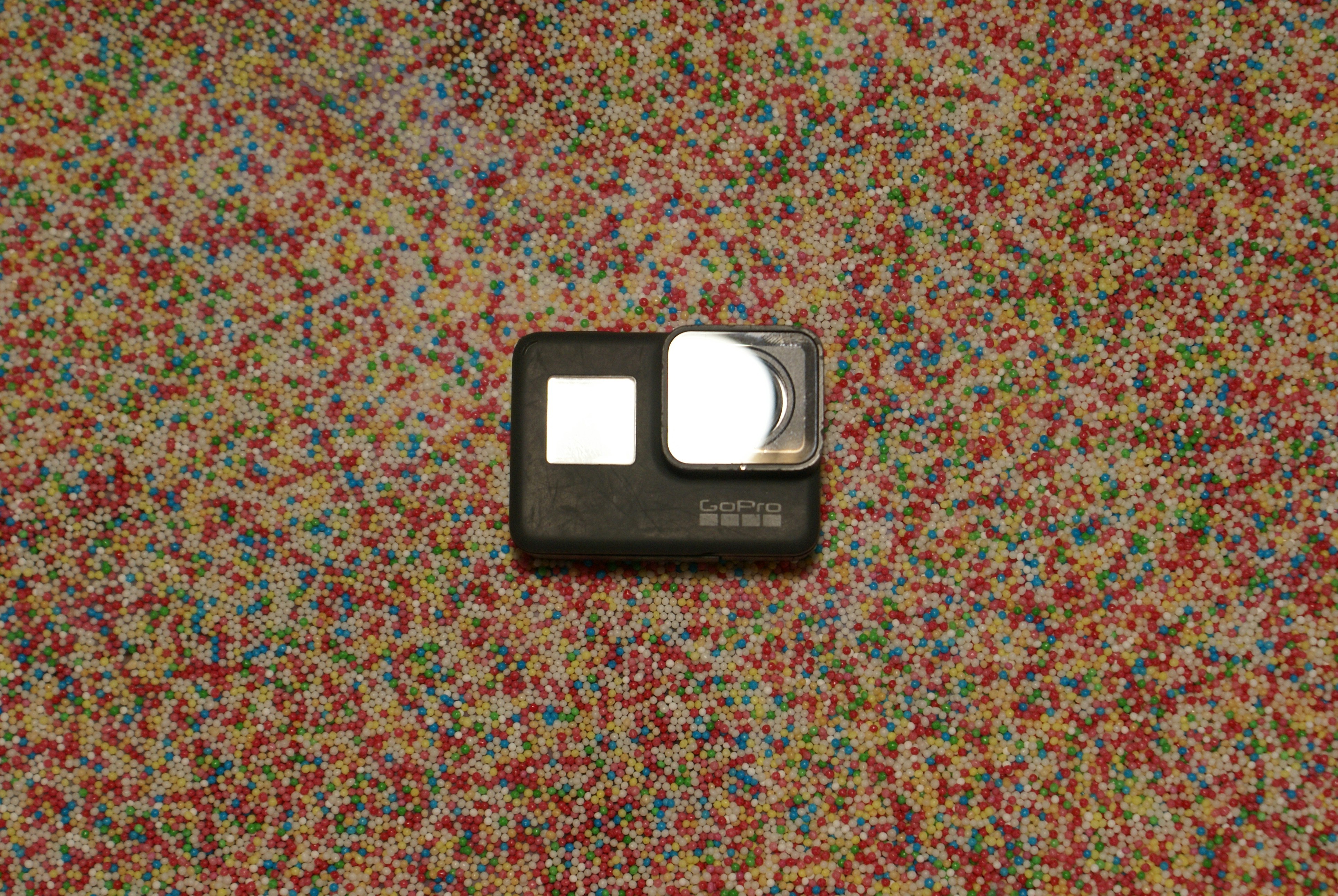 GoPro camera resting on a vibrant, speckled surface that resembles a playful candy landscape.