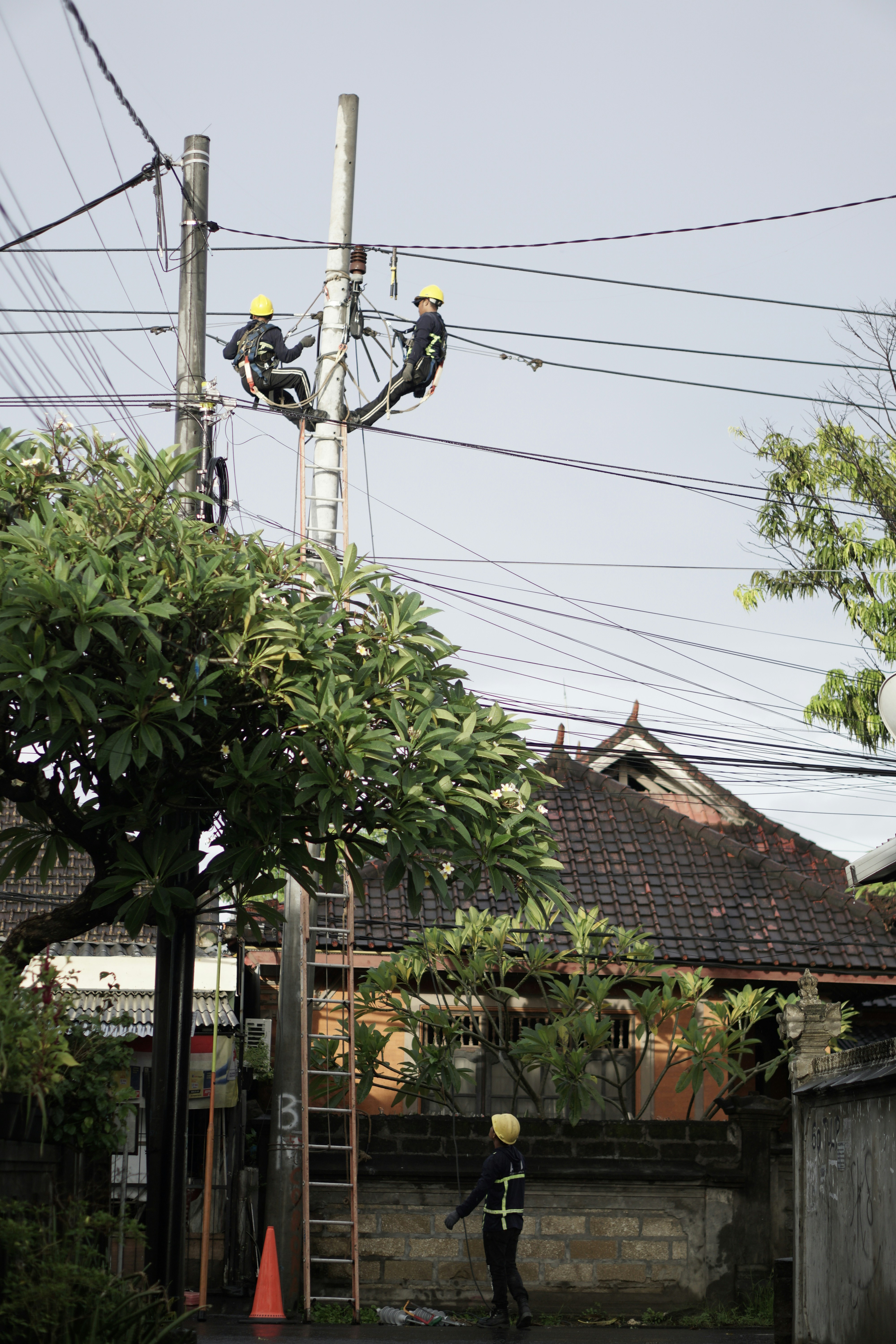 A man in a yellow safety vest working on a power line photo – Free ...
