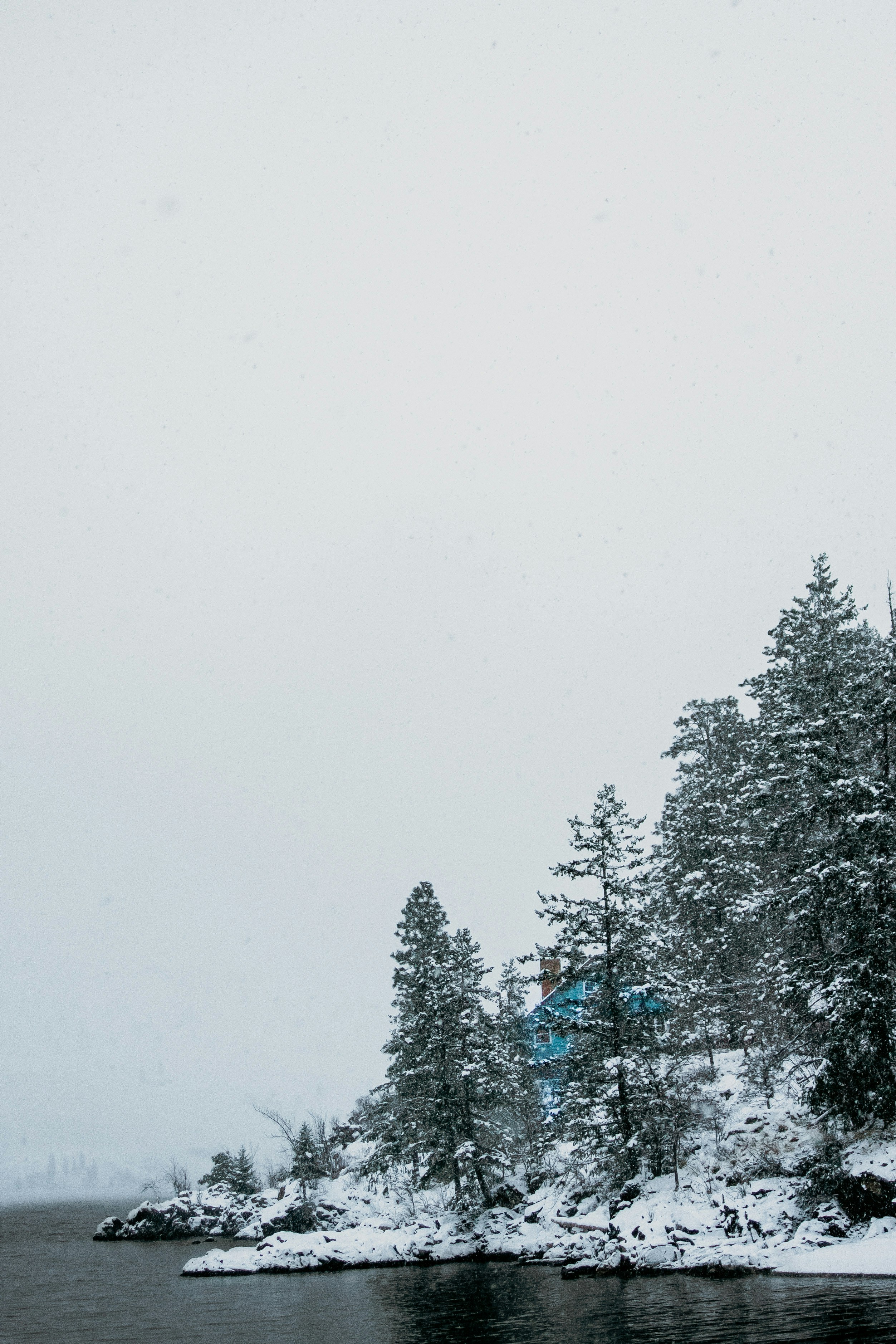 A snow covered island in the middle of a lake photo – Free Grey Image ...