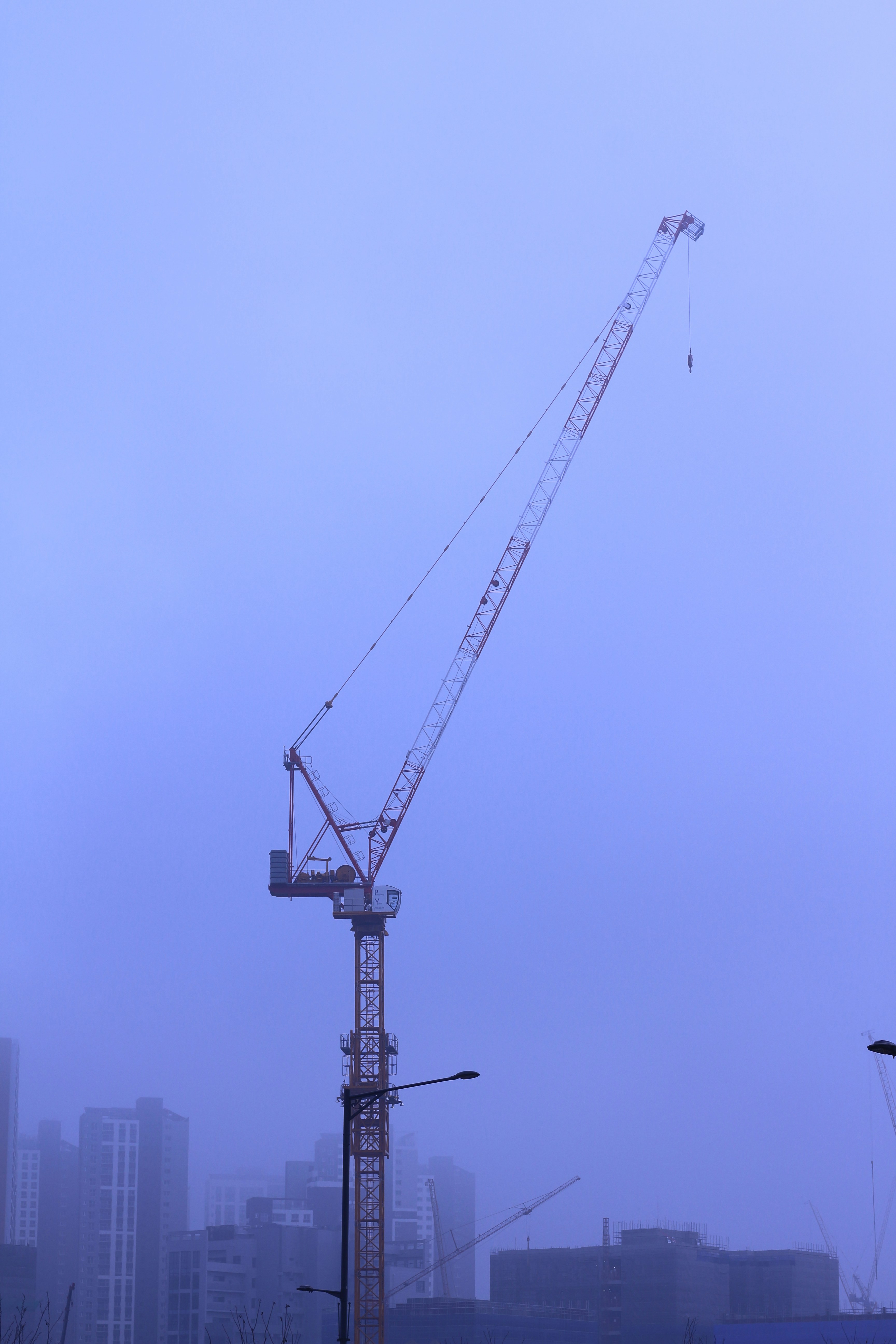 Construction Crane Reaching into a Misty Skyline