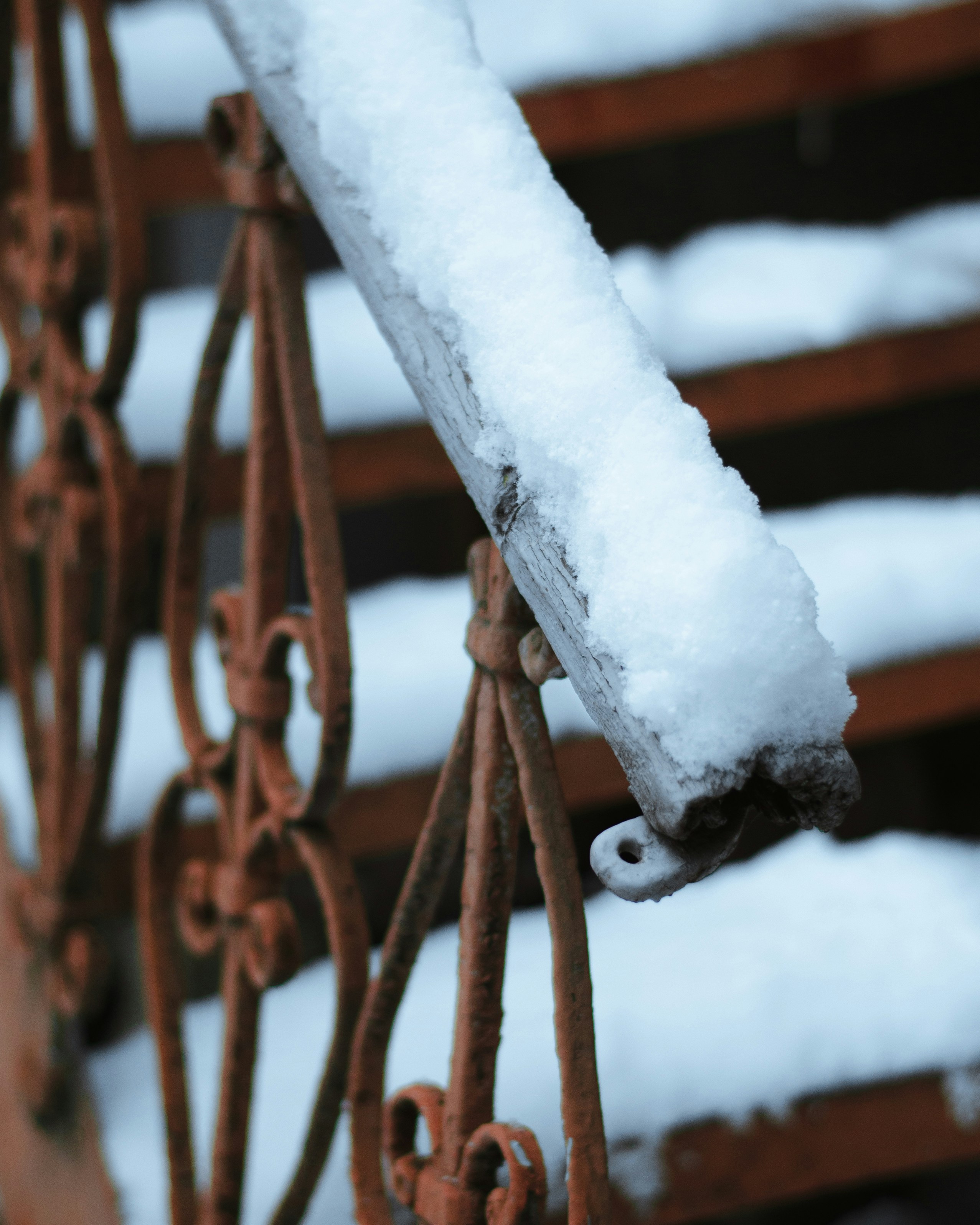 a metal fence with snow on top of it