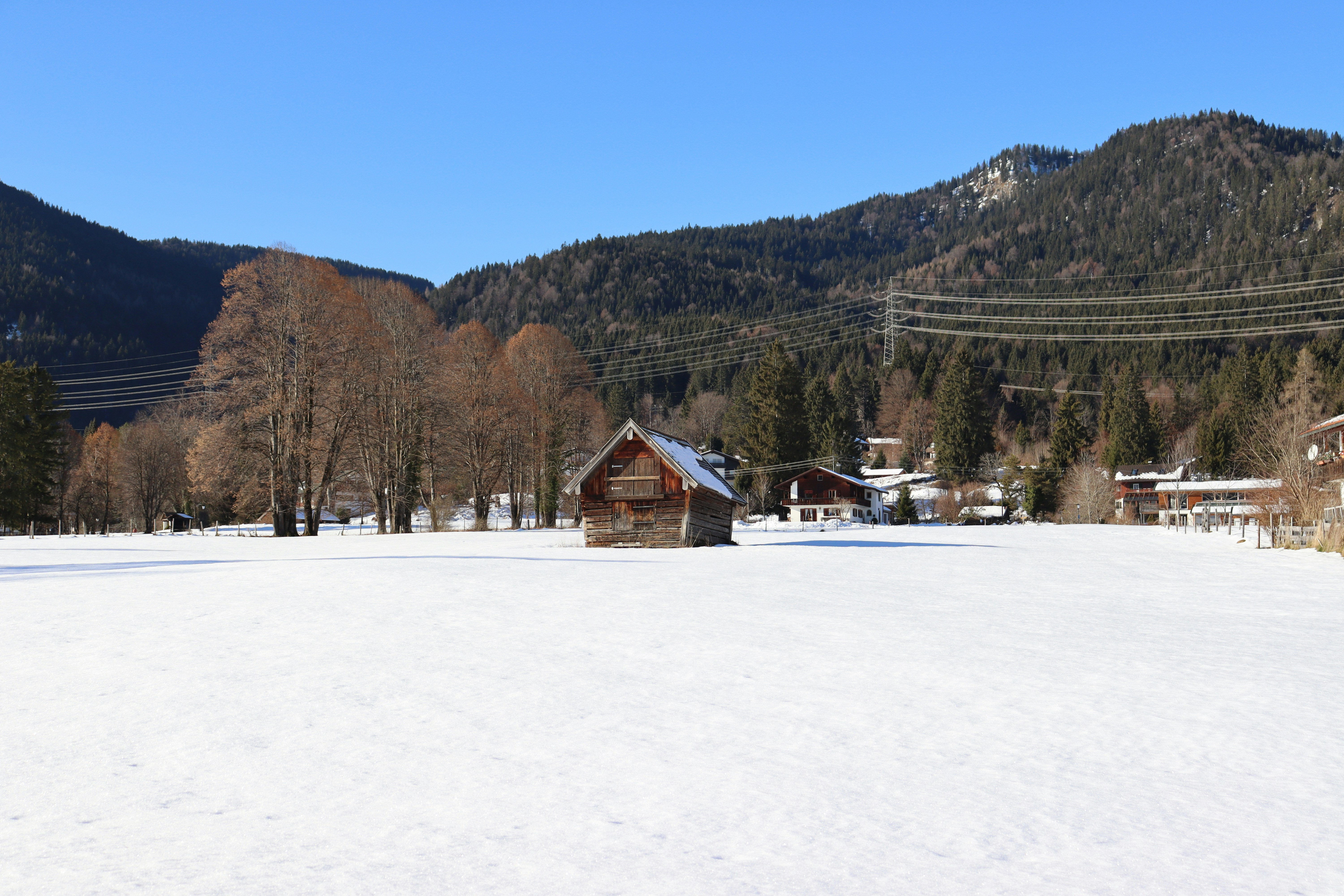 a snow covered field with a house in the background