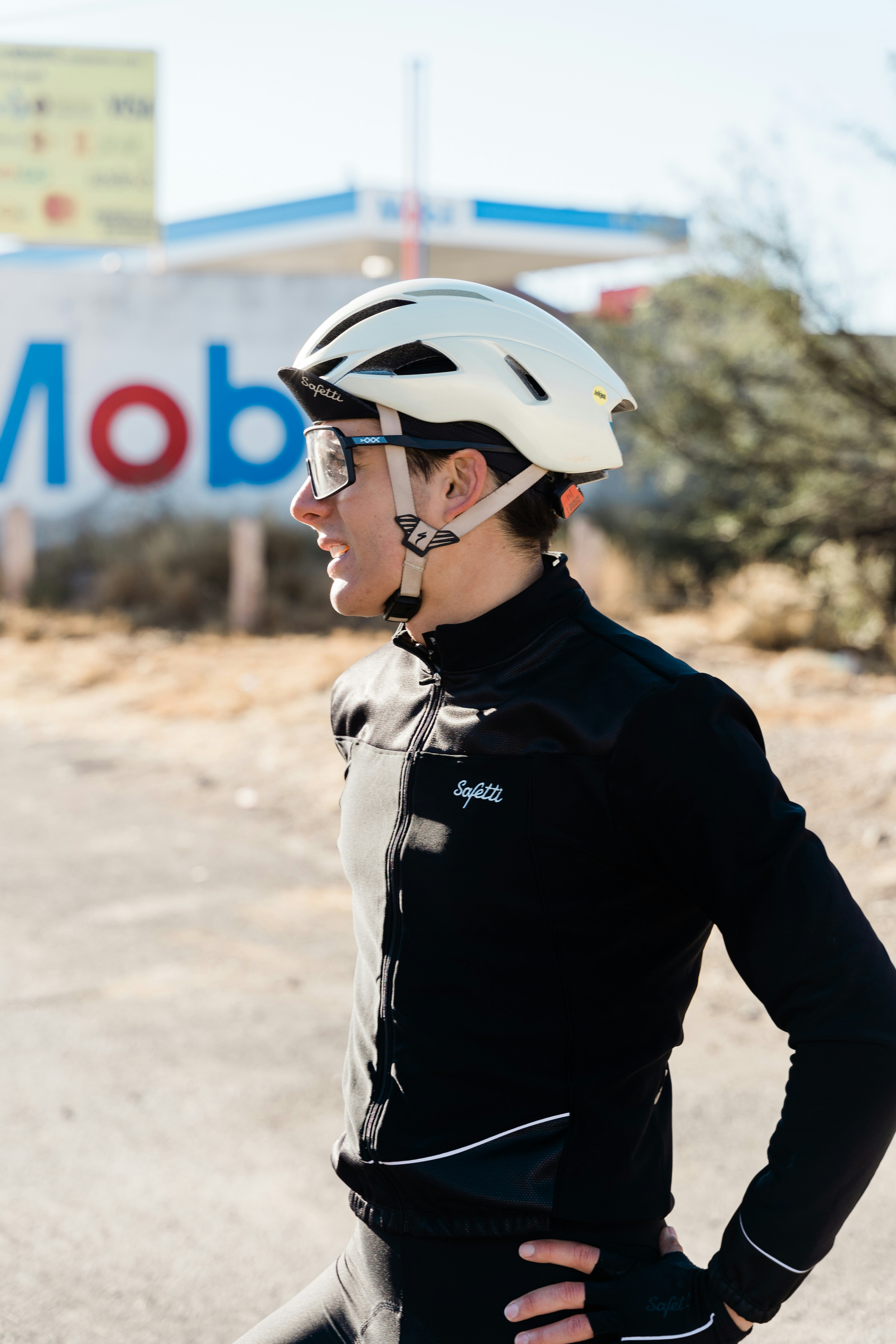 Helmeted Cyclist in Profile at a Sunny Stop