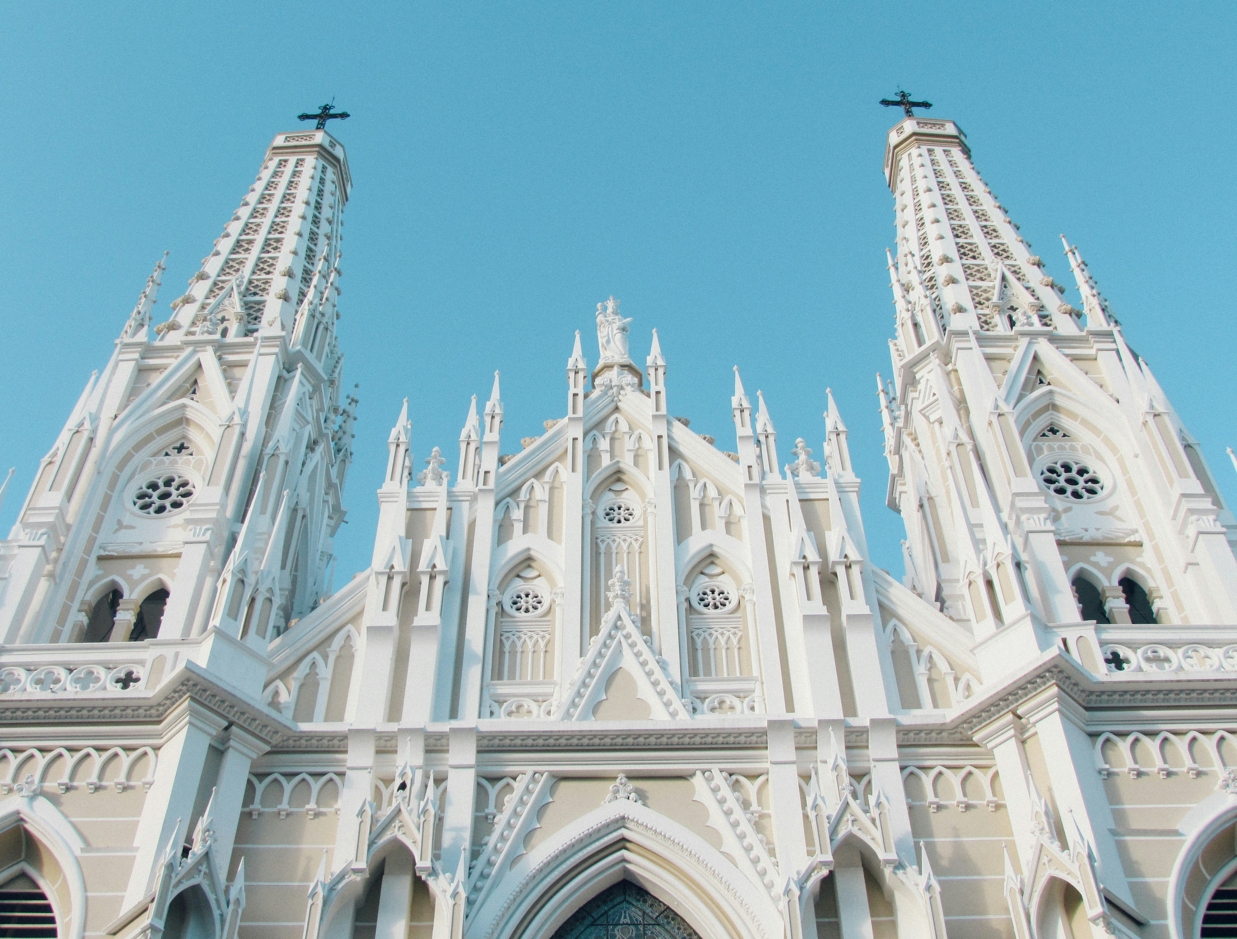 Gothic-style cathedral with two soaring spires set against a clear blue sky.