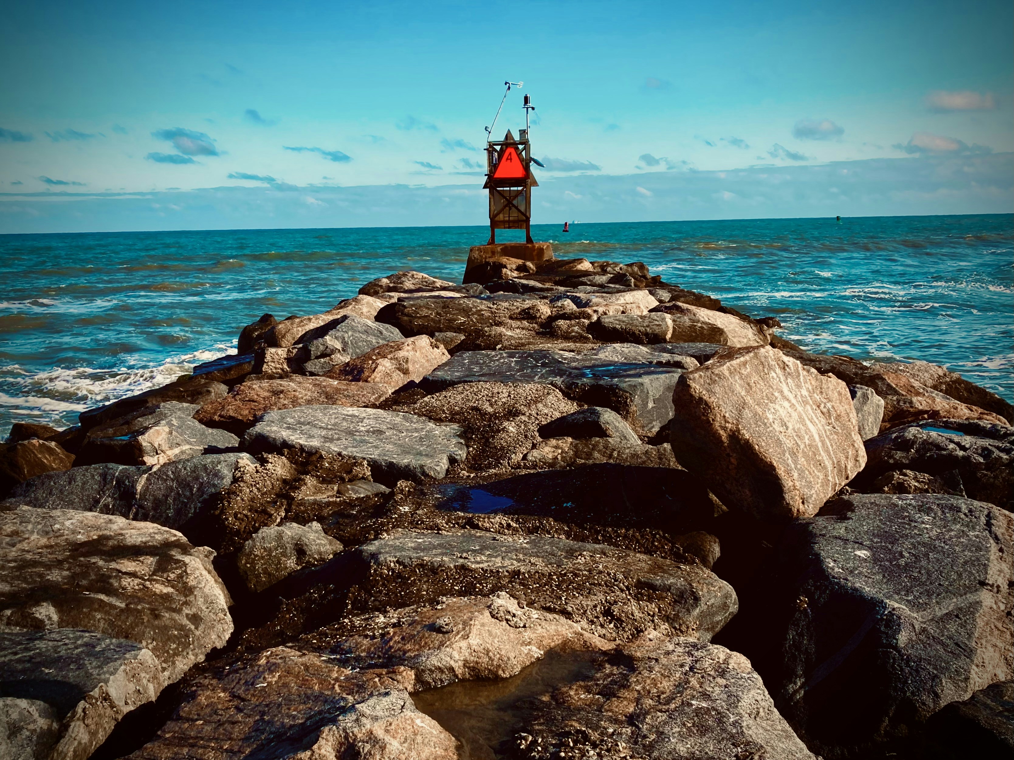 Un homme debout au sommet d’une jetée rocheuse au bord de l’océan photo ...