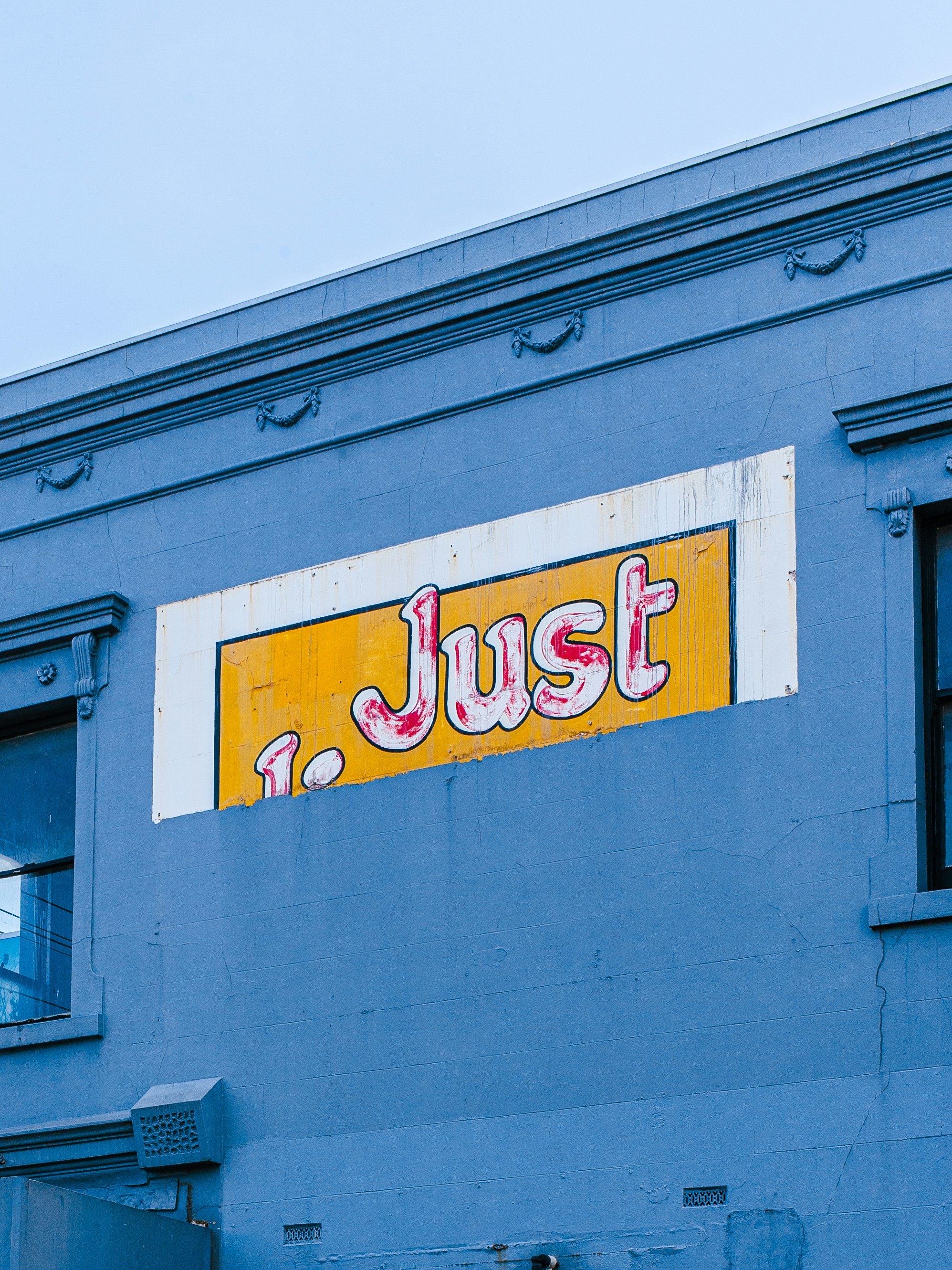 Yellow Sign on a Blue Wall: A Quiet Urban Portrait
