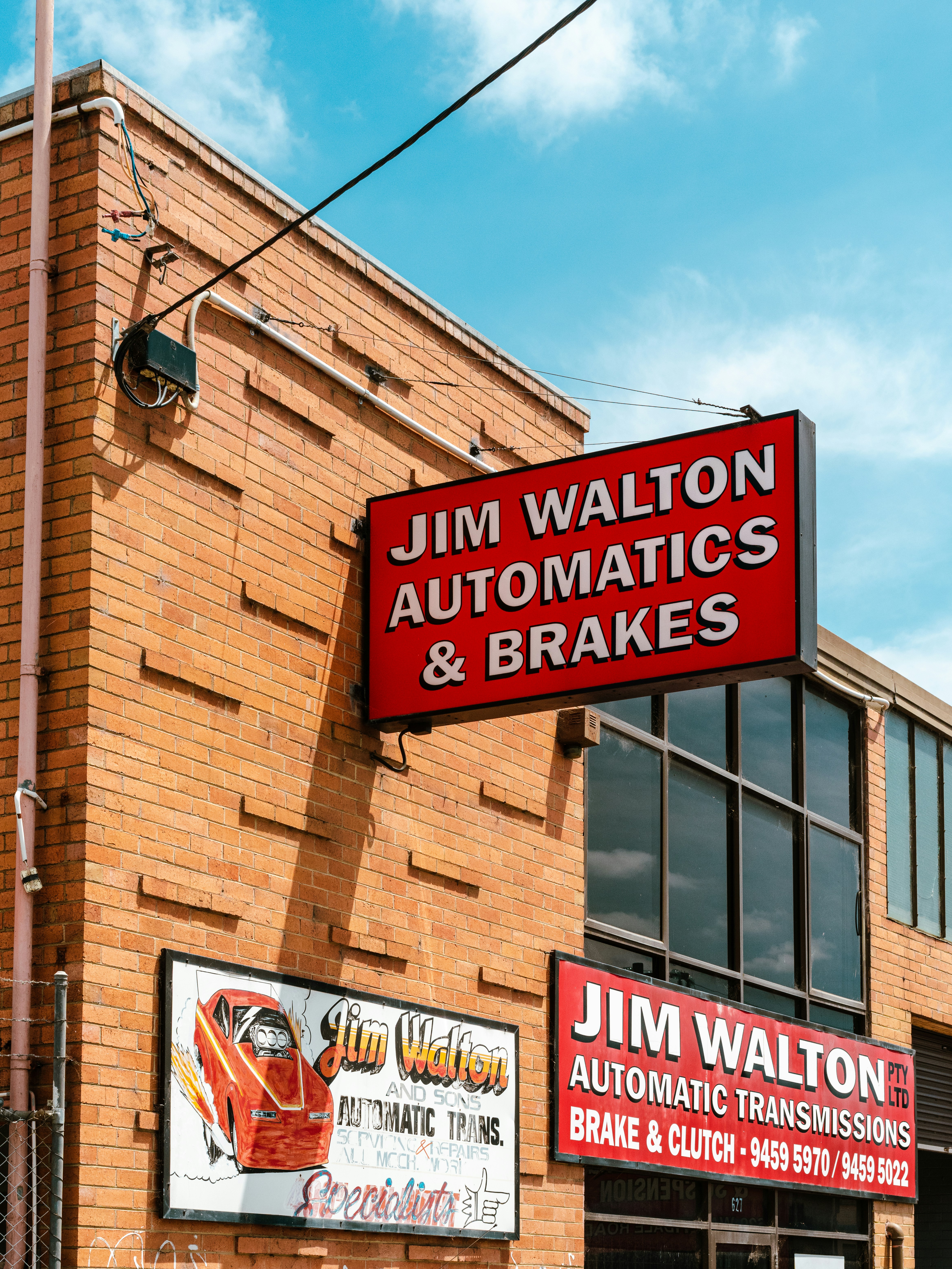 Jim Walton Auto Emporium: Brick Facade Under a Bright Blue Sky