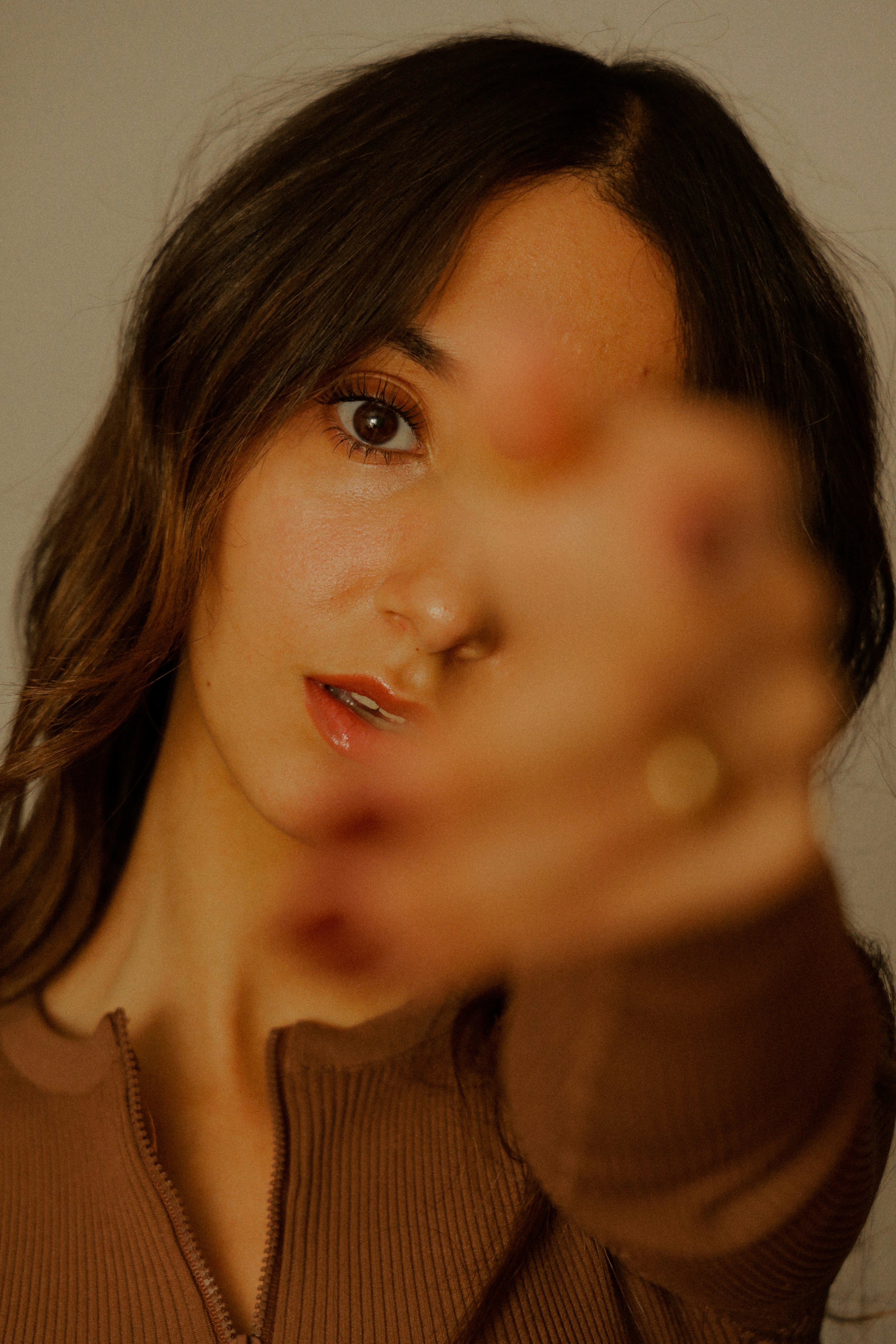 Gaze Through the Blur: A Warm Studio Portrait with Foreground Depth