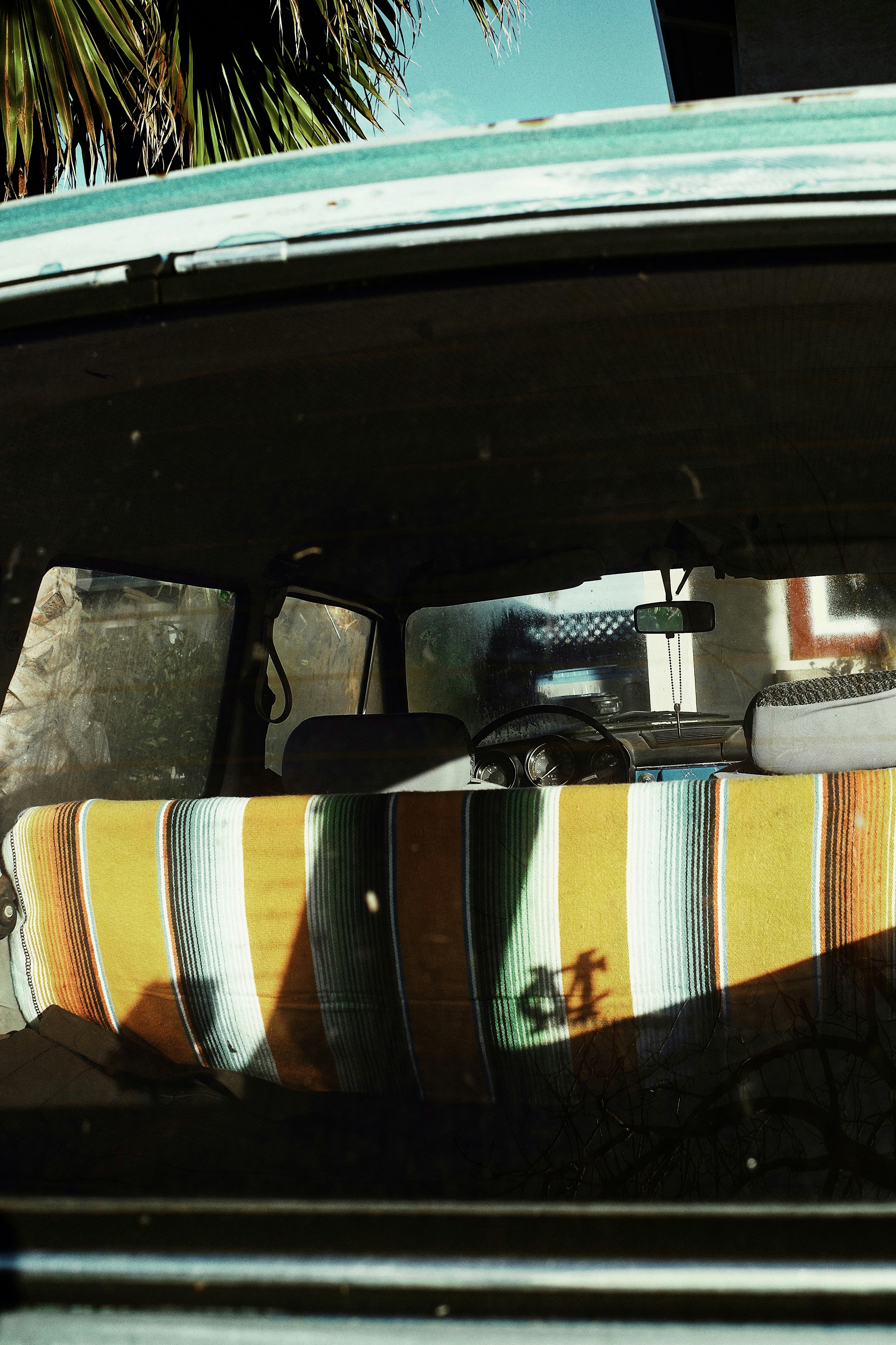Stripe-lit Vintage: A Car Interior Framed by Sun Through the Rear Window