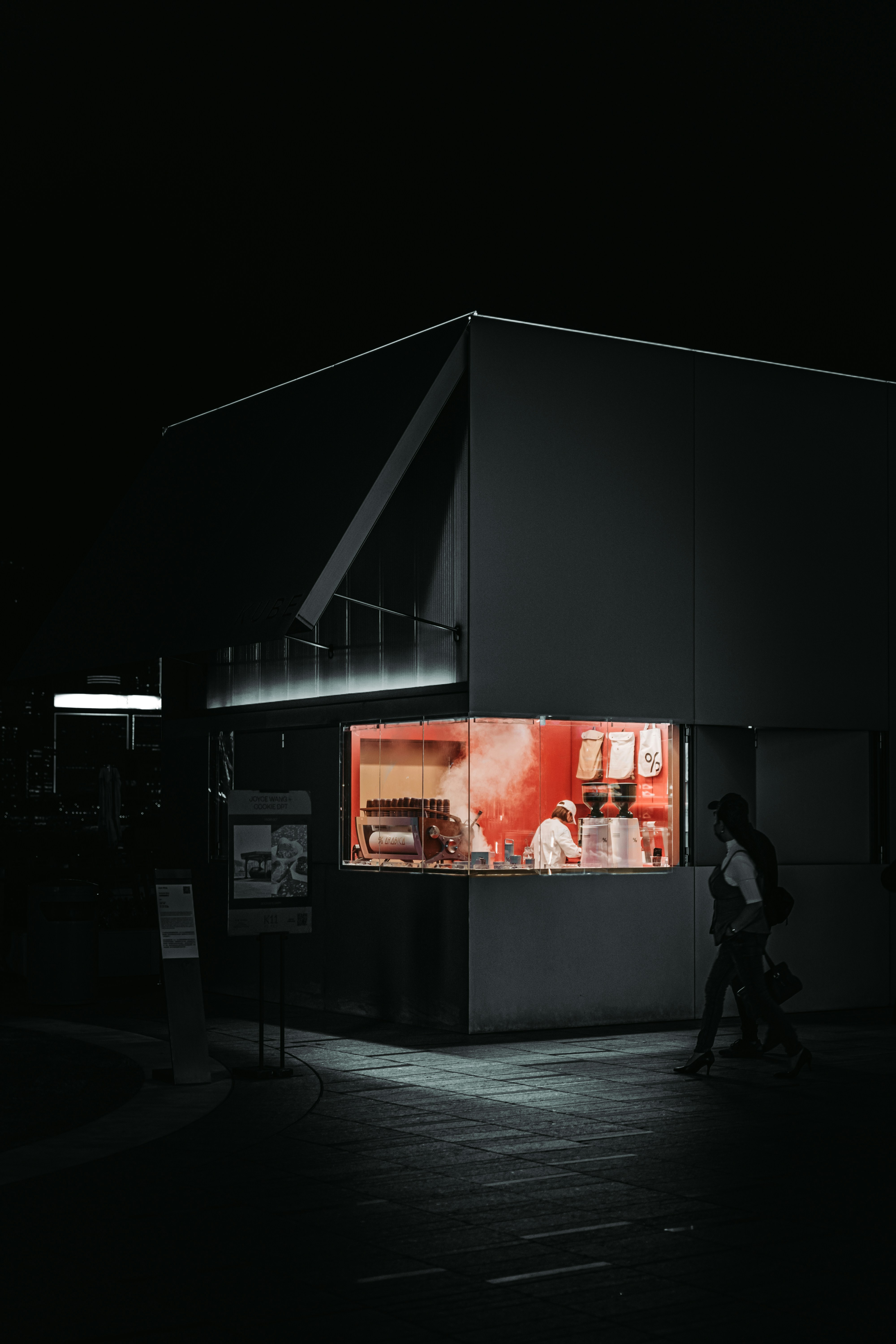 A person walking past a building at night photo – Free Human Image on ...