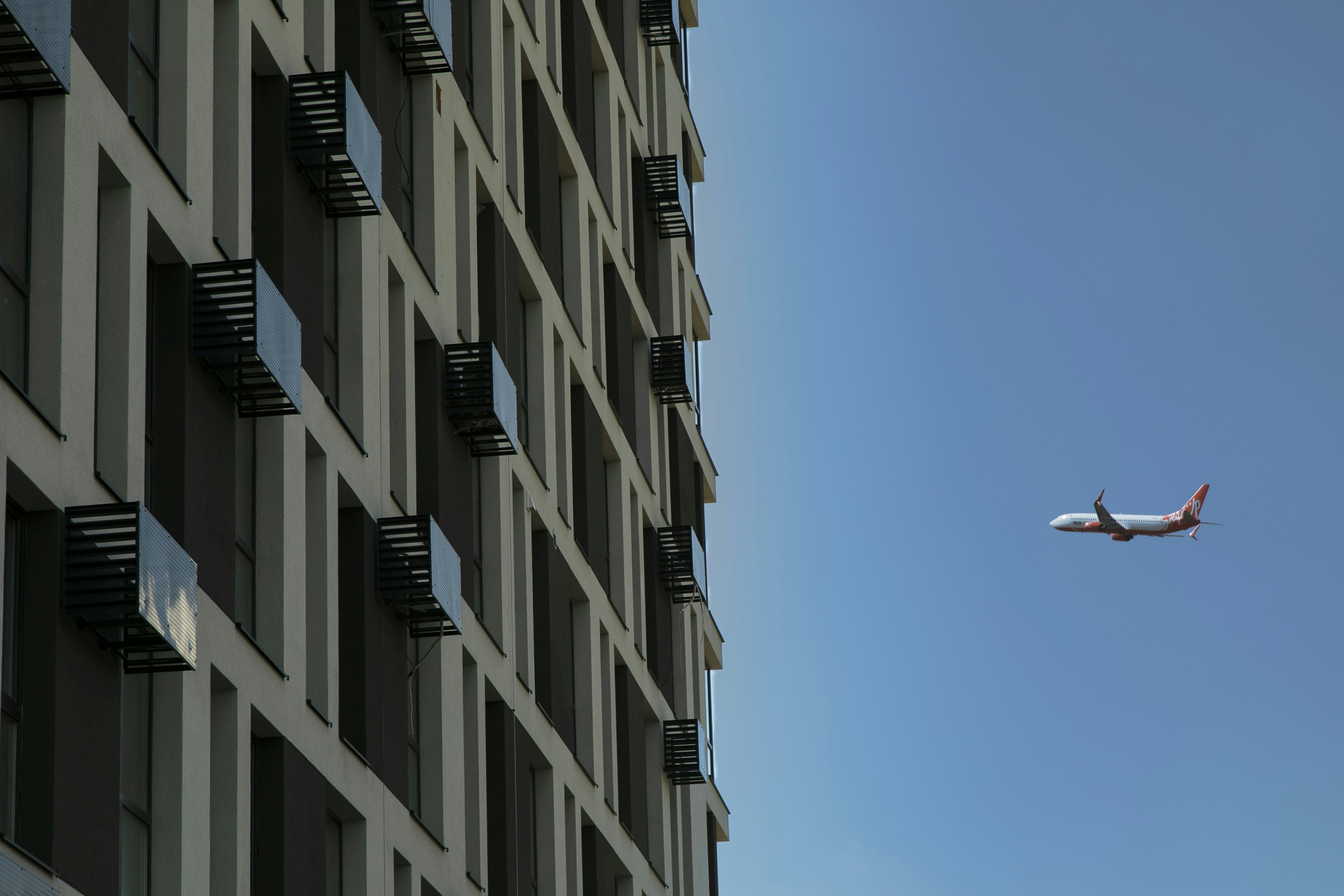 Jet Across the Grid: A Plane Slices Past a Repeating Facade