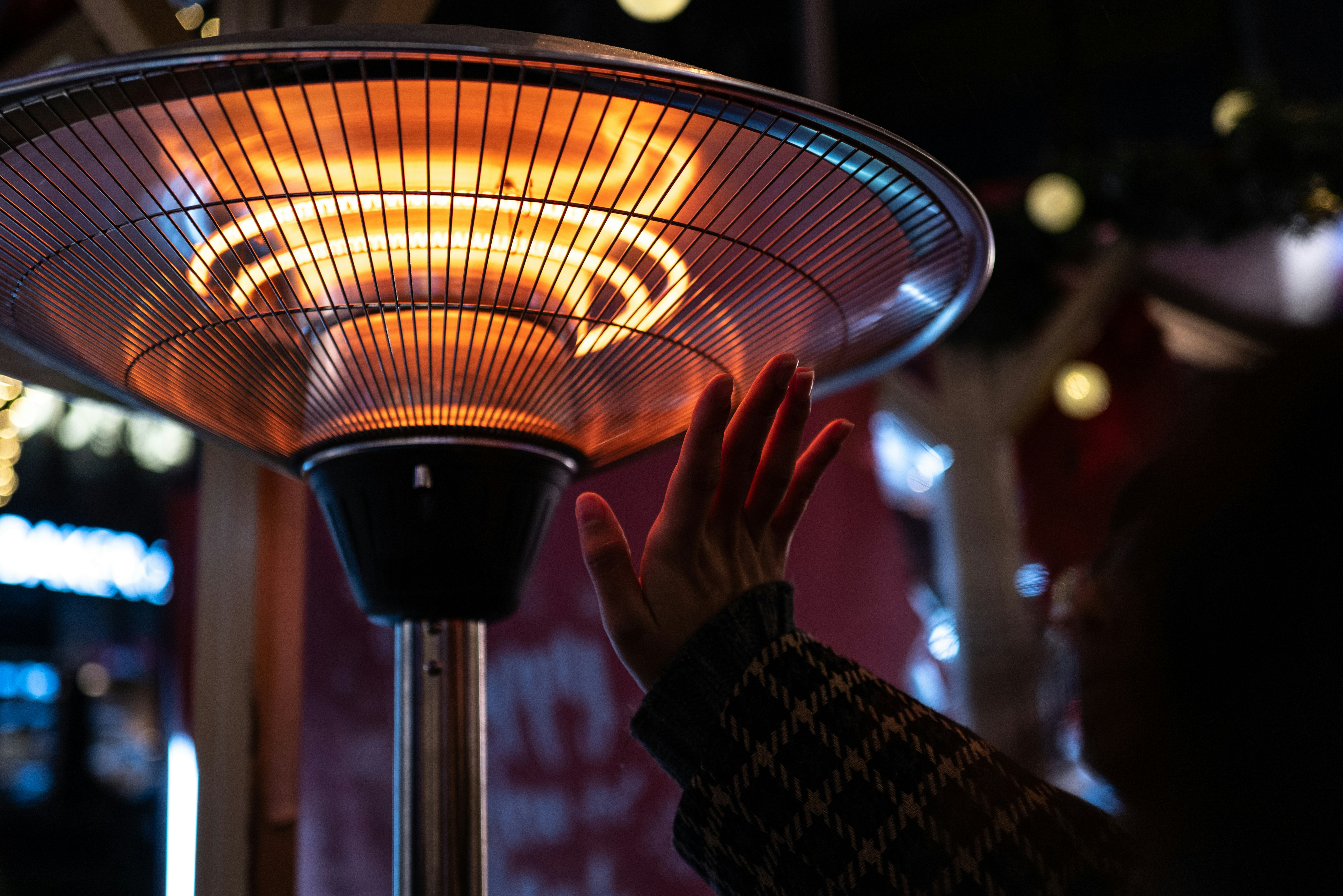 Ember Halo at Night: A Hand Reaches Toward the Patio Heater