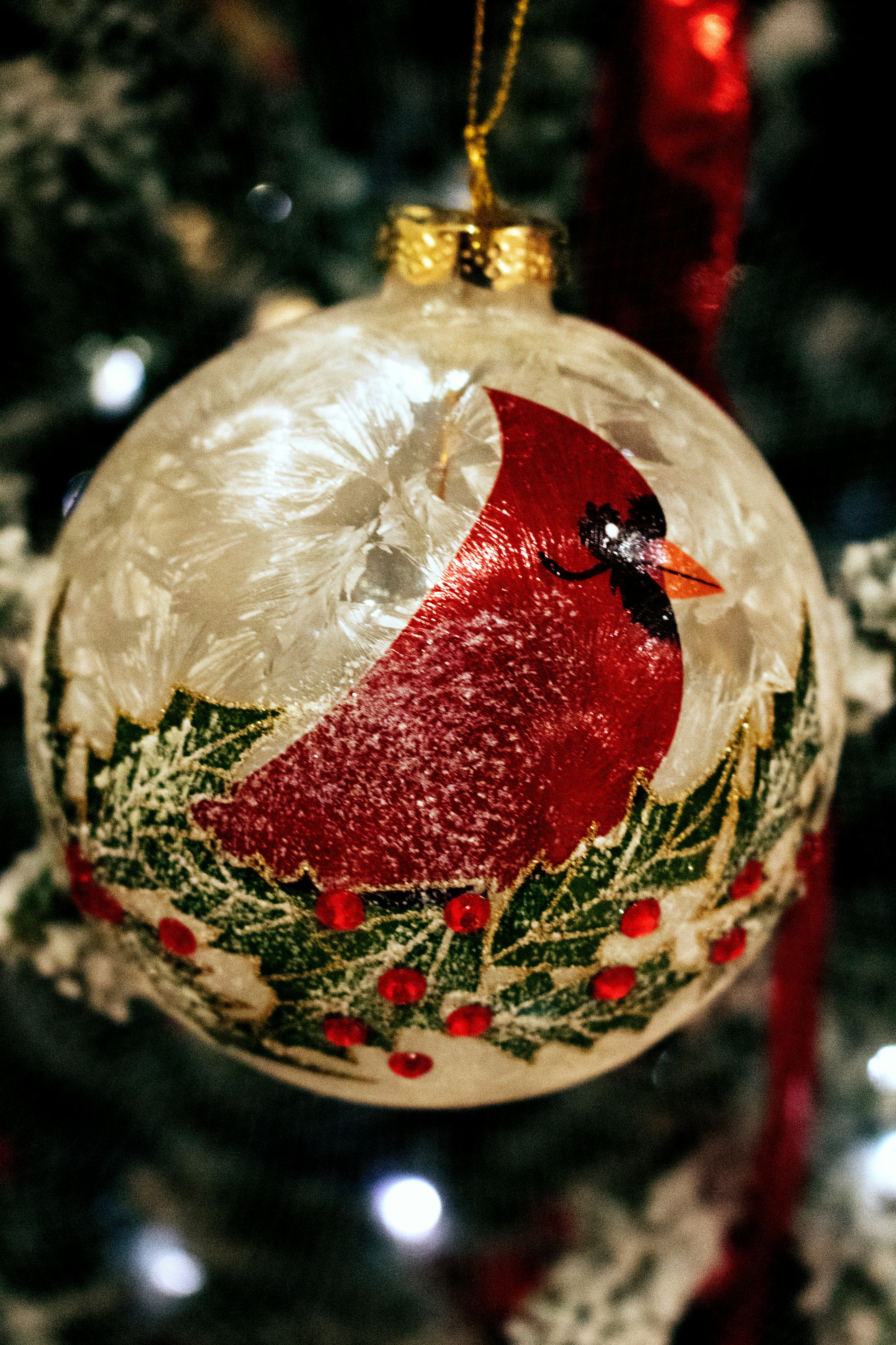Crimson Cardinal on Frosted Ornament Under Soft Holiday Glow