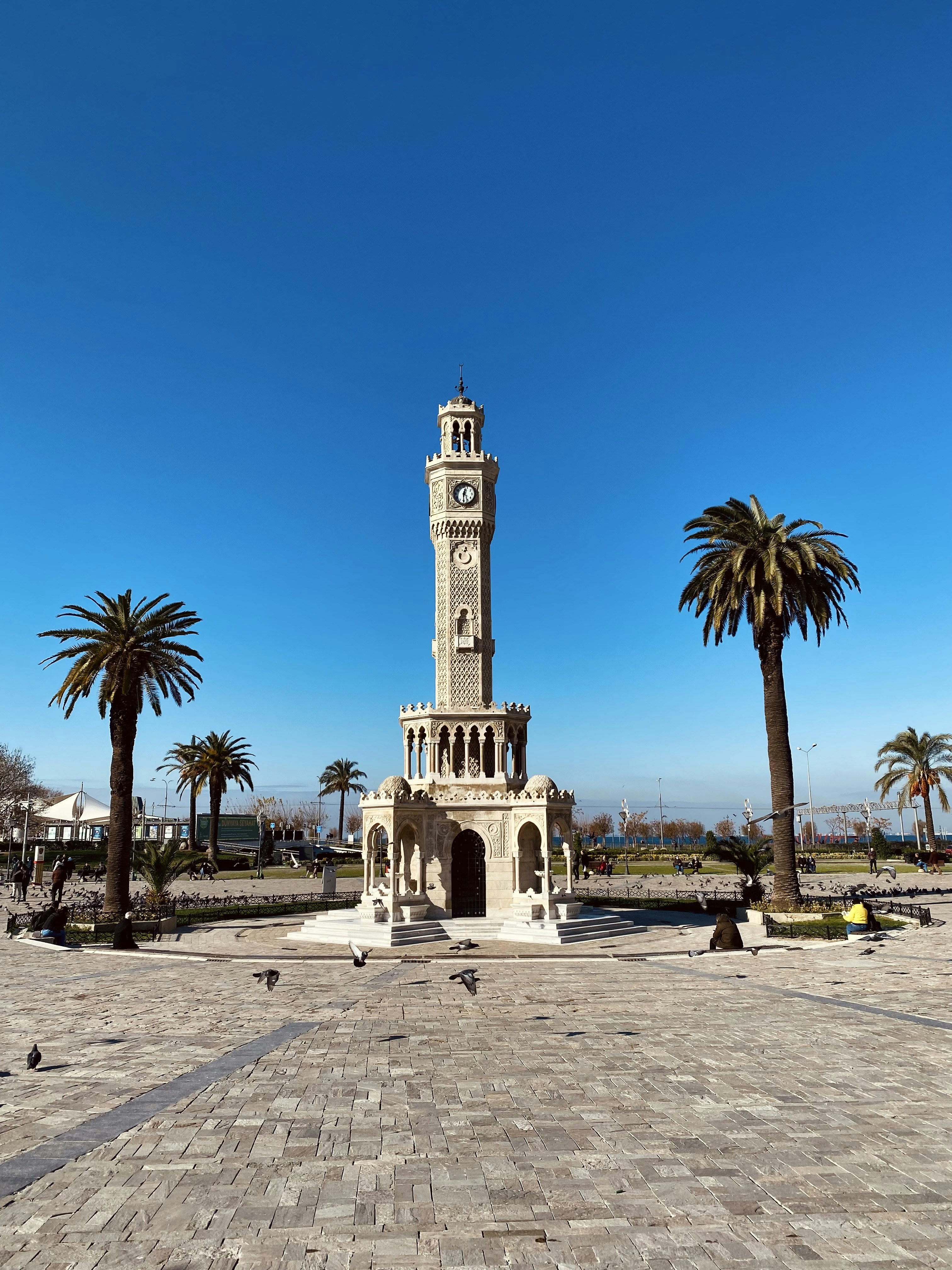 A clock tower in a plaza with palm trees photo – Free İzmir Image on ...
