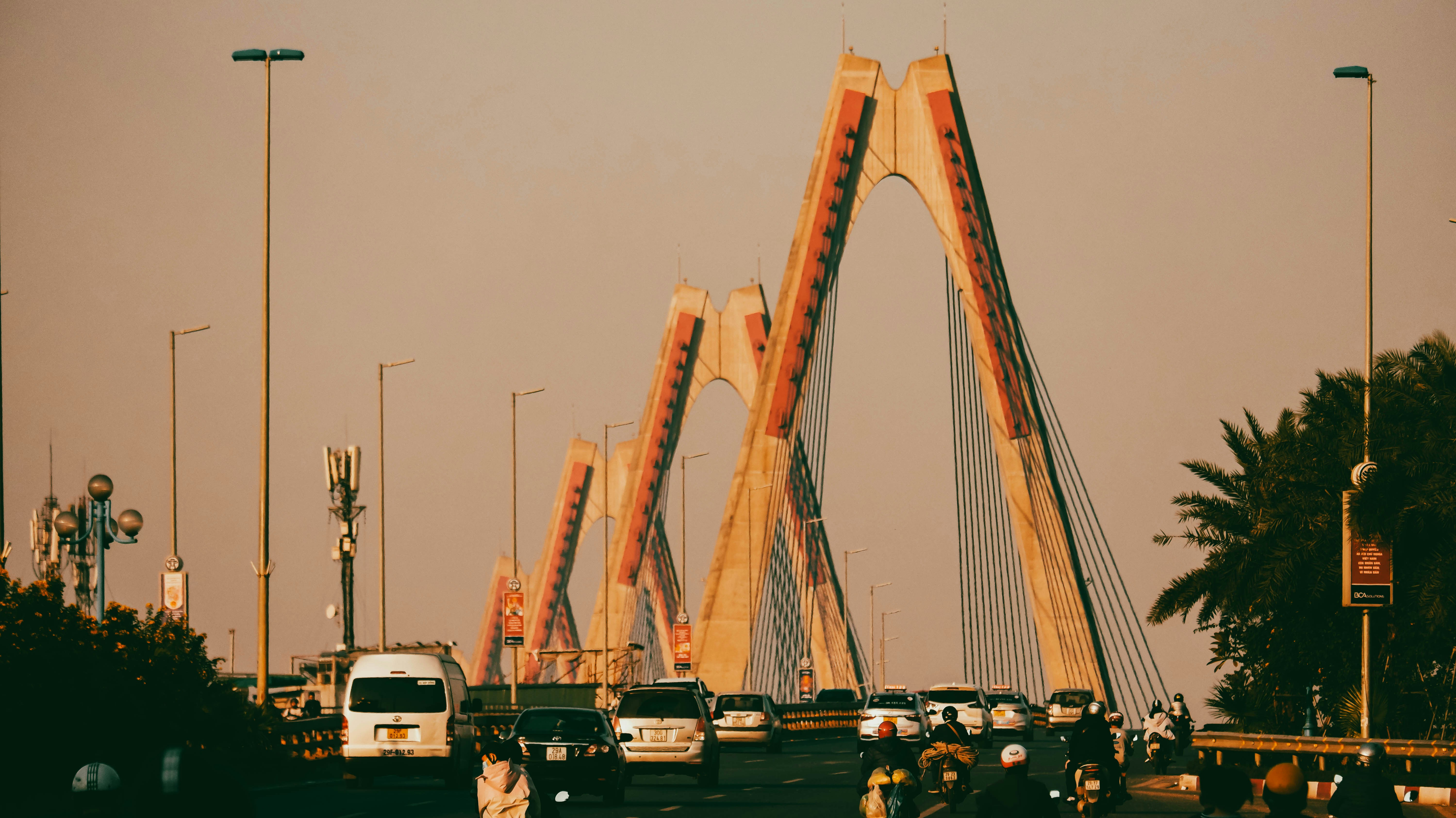 Dusk Over the Cable-Arch Bridge: Traffic Flows Beneath Golden Arches
