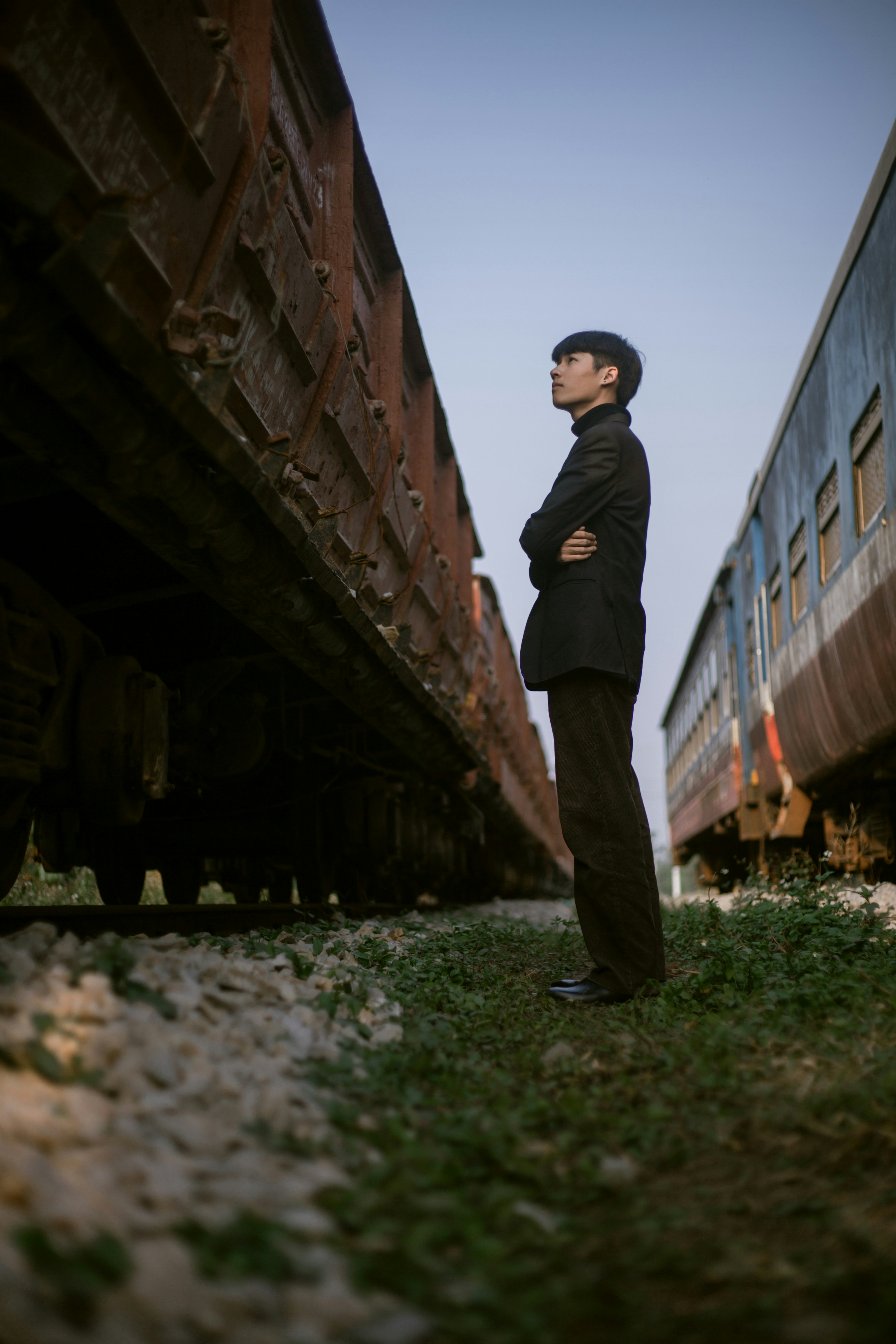 Between the Rails: A Quiet Silhouette Amid Rusted Giants