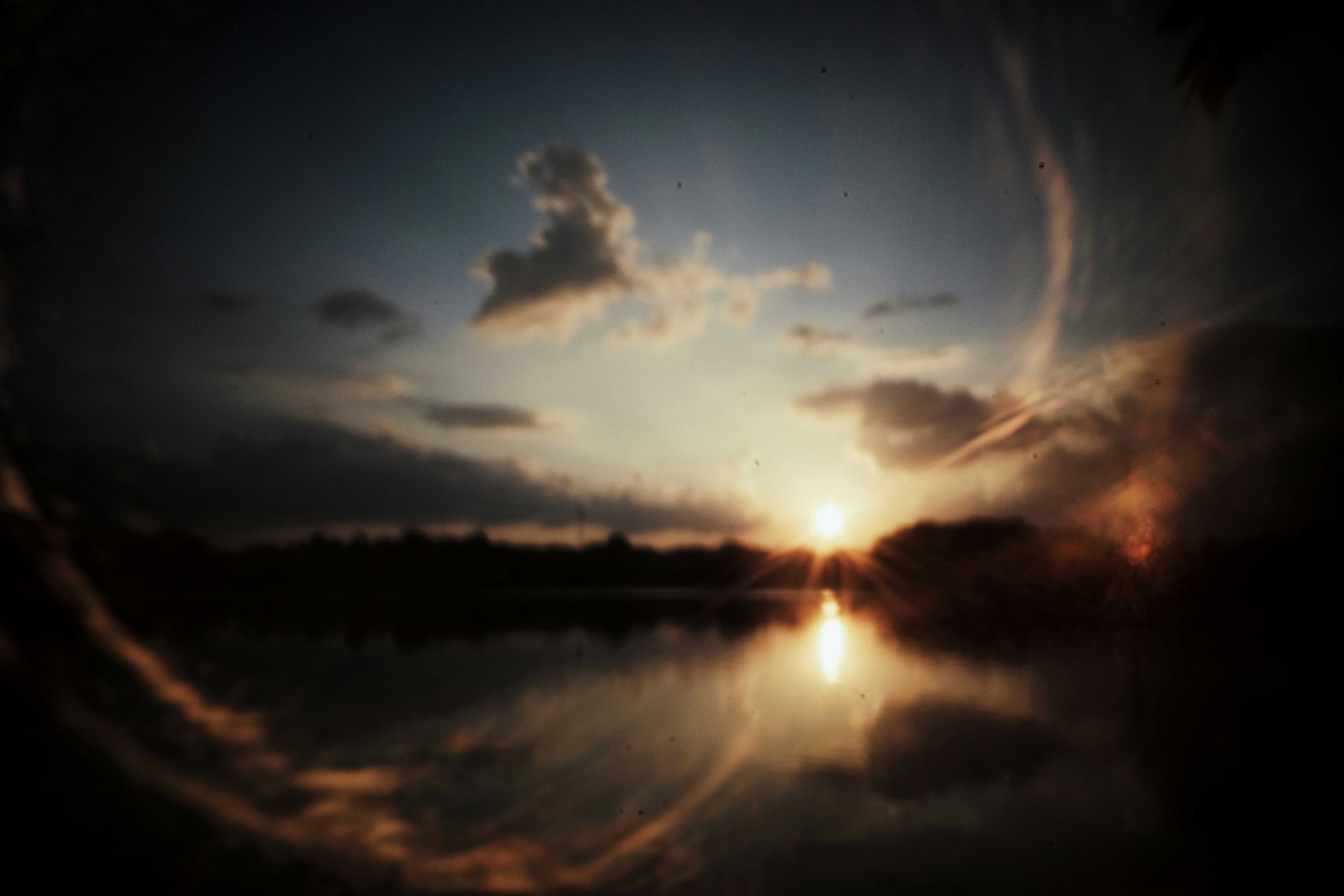 The sun is setting over a body of water photo – Free Pinhole Image on ...