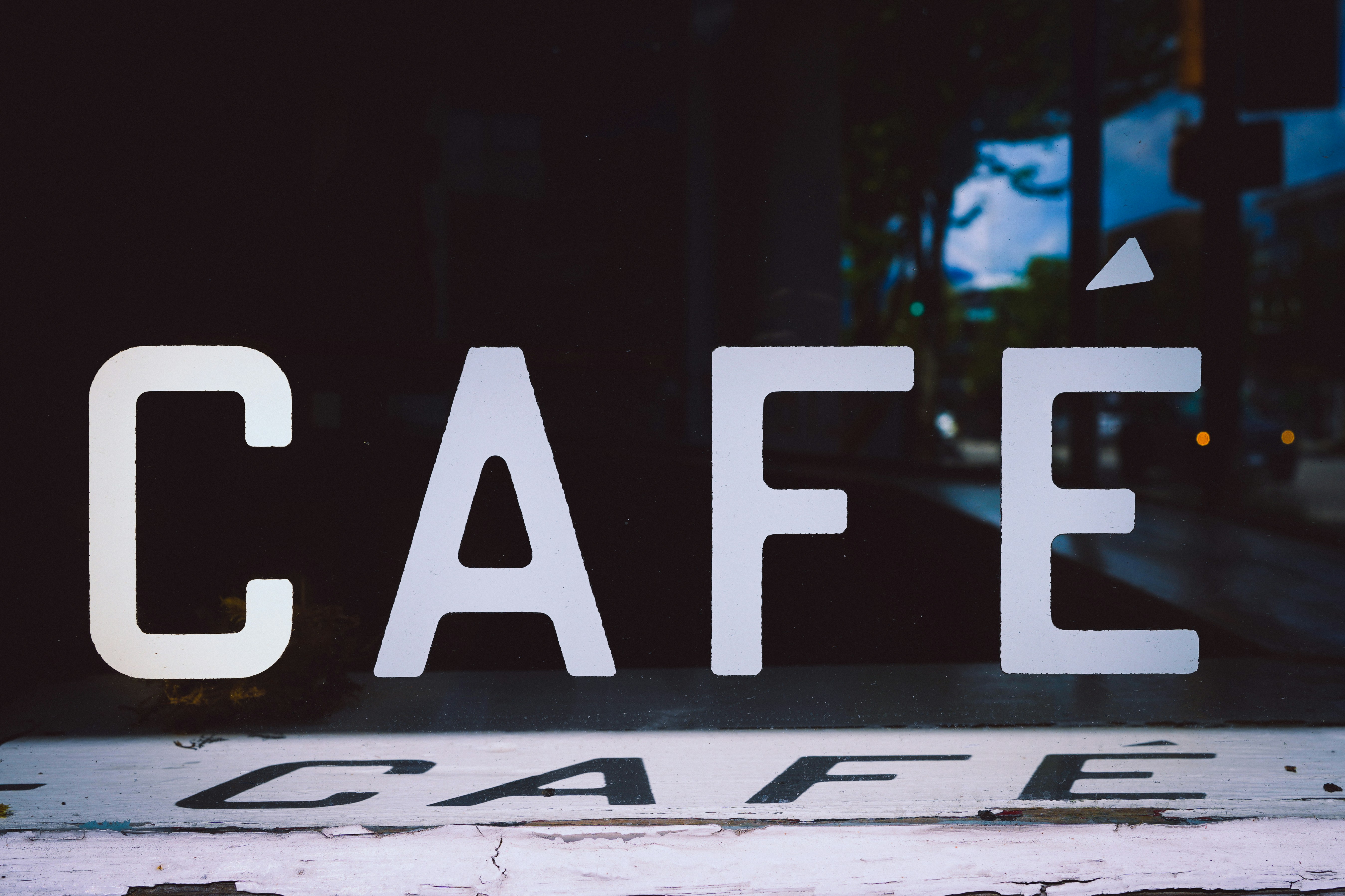 Stylized café sign reflecting the urban environment, showcasing the blend of modern and classic design elements.