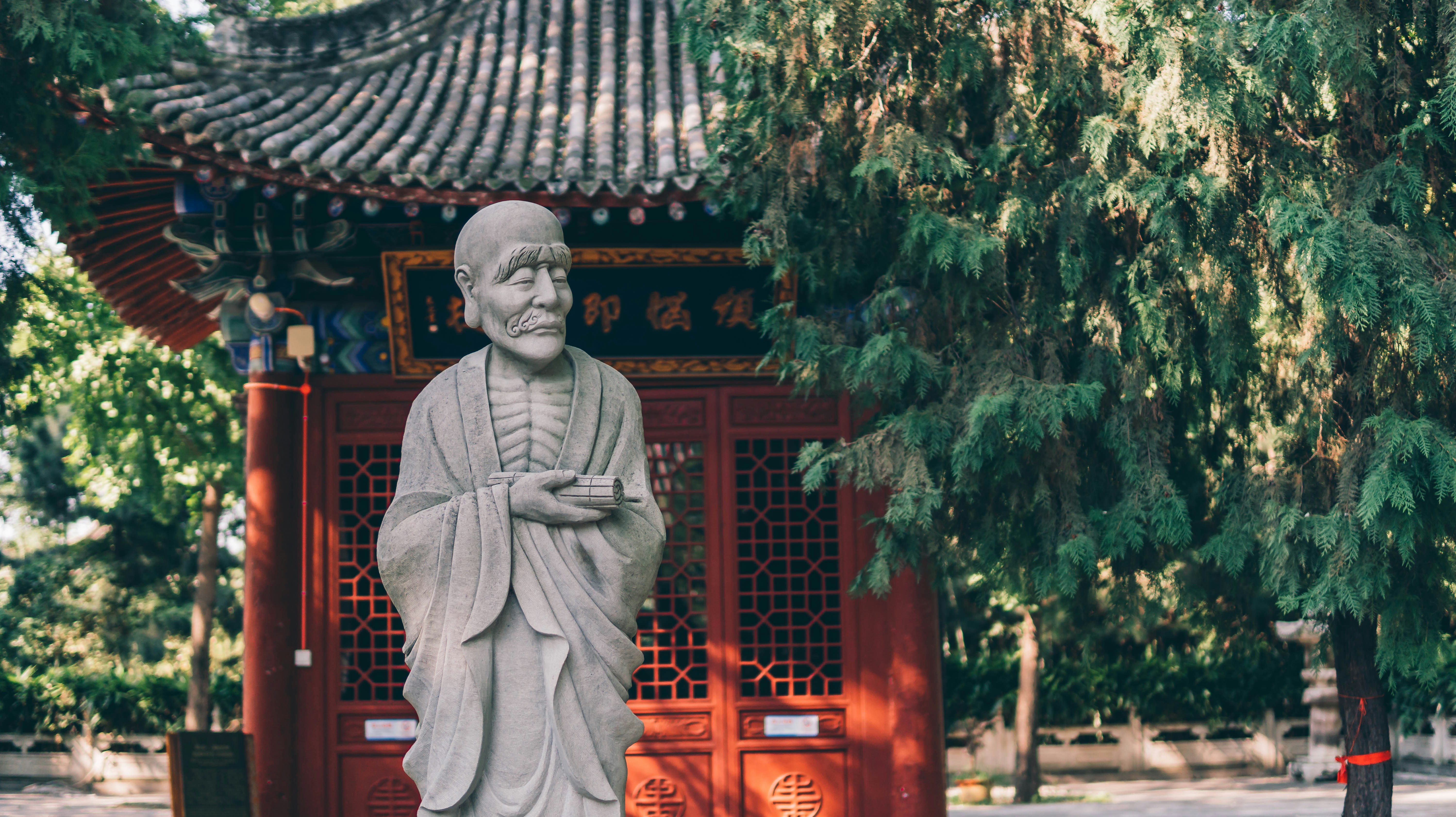 A statue of a man standing in front of a building photo – Free 寺庙 Image ...