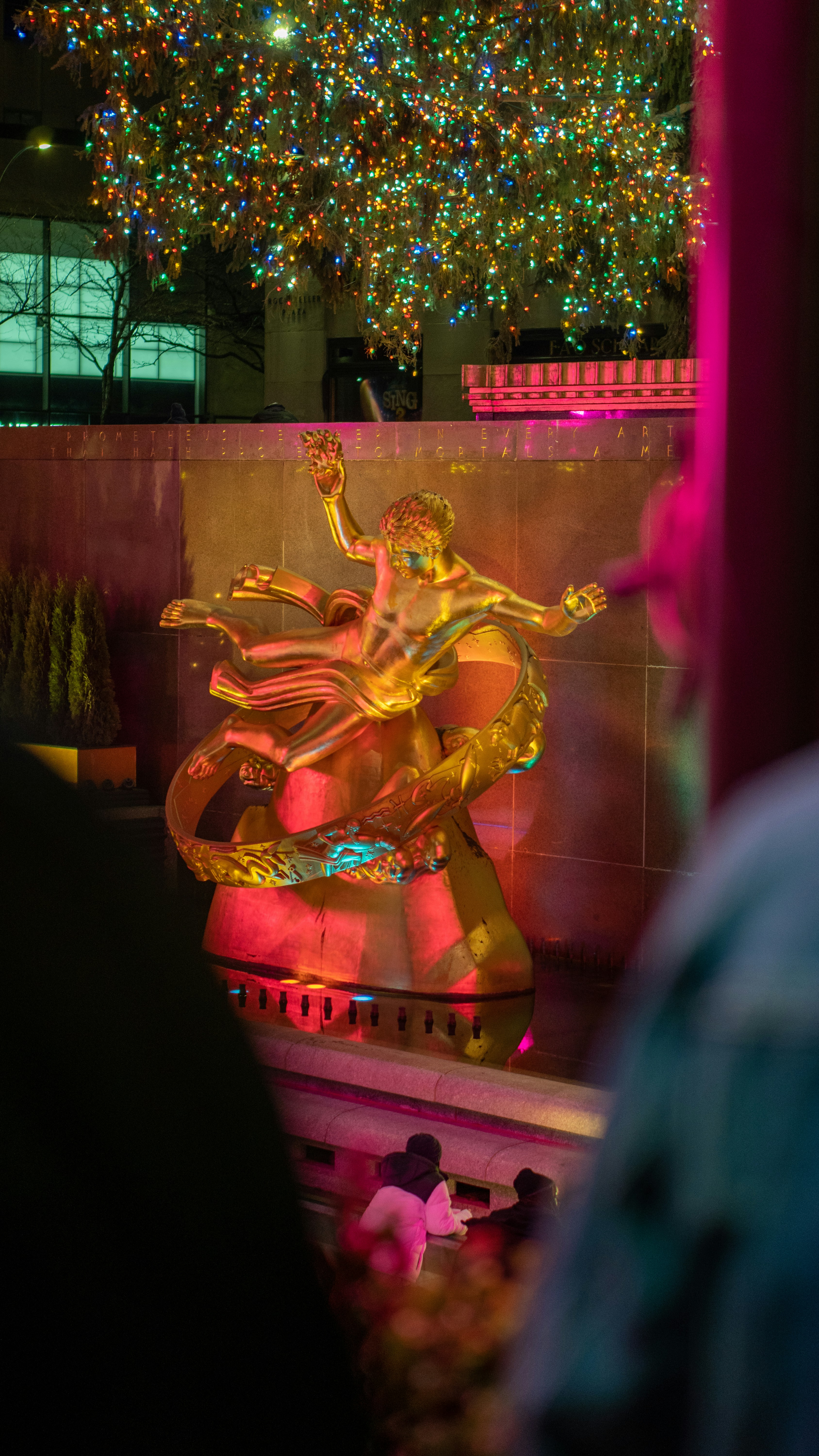 Golden sculpture under multicolored holiday lights