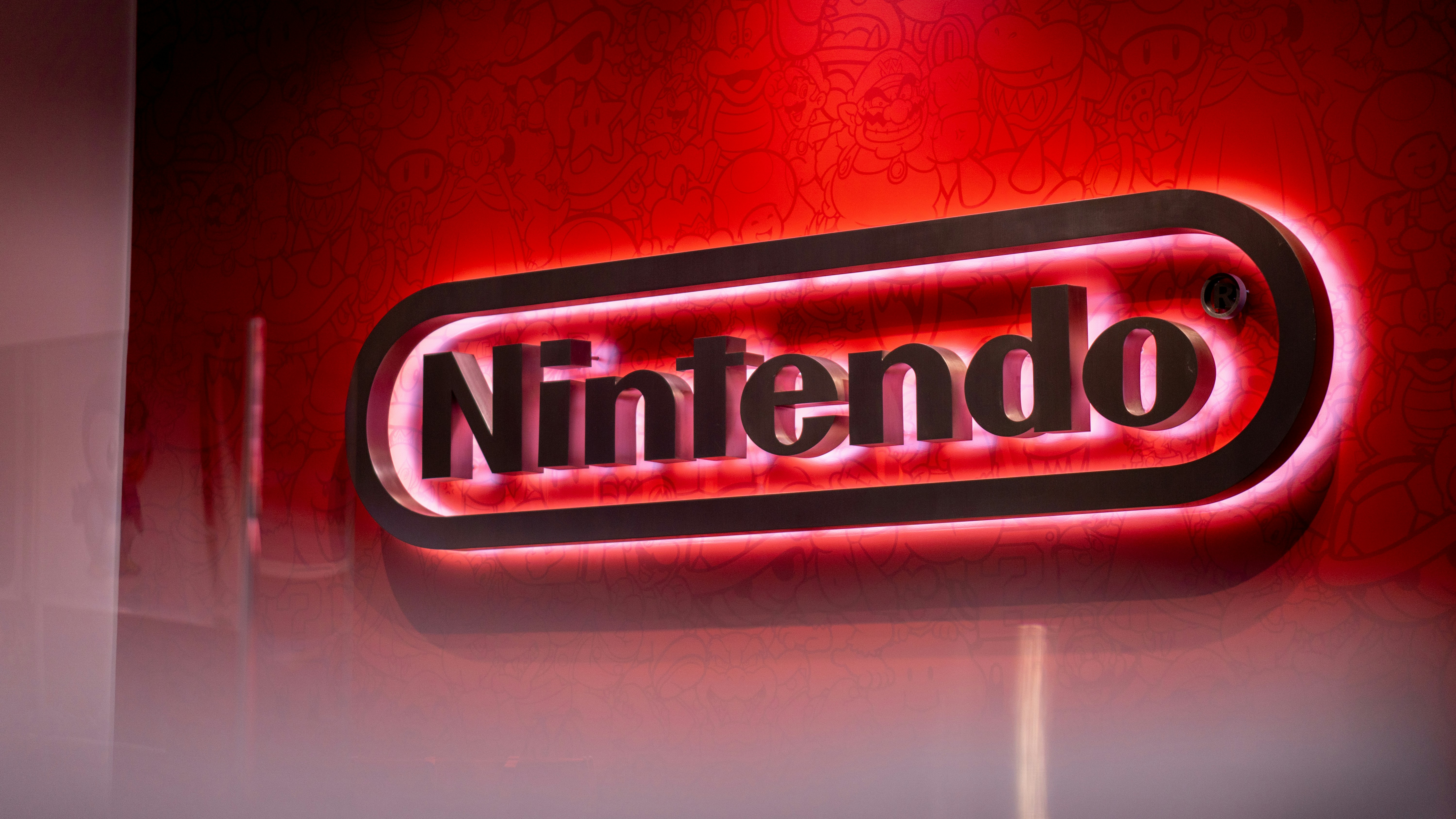 A nintendo logo lit up on a red wall photo – Free Ny Image on Unsplash