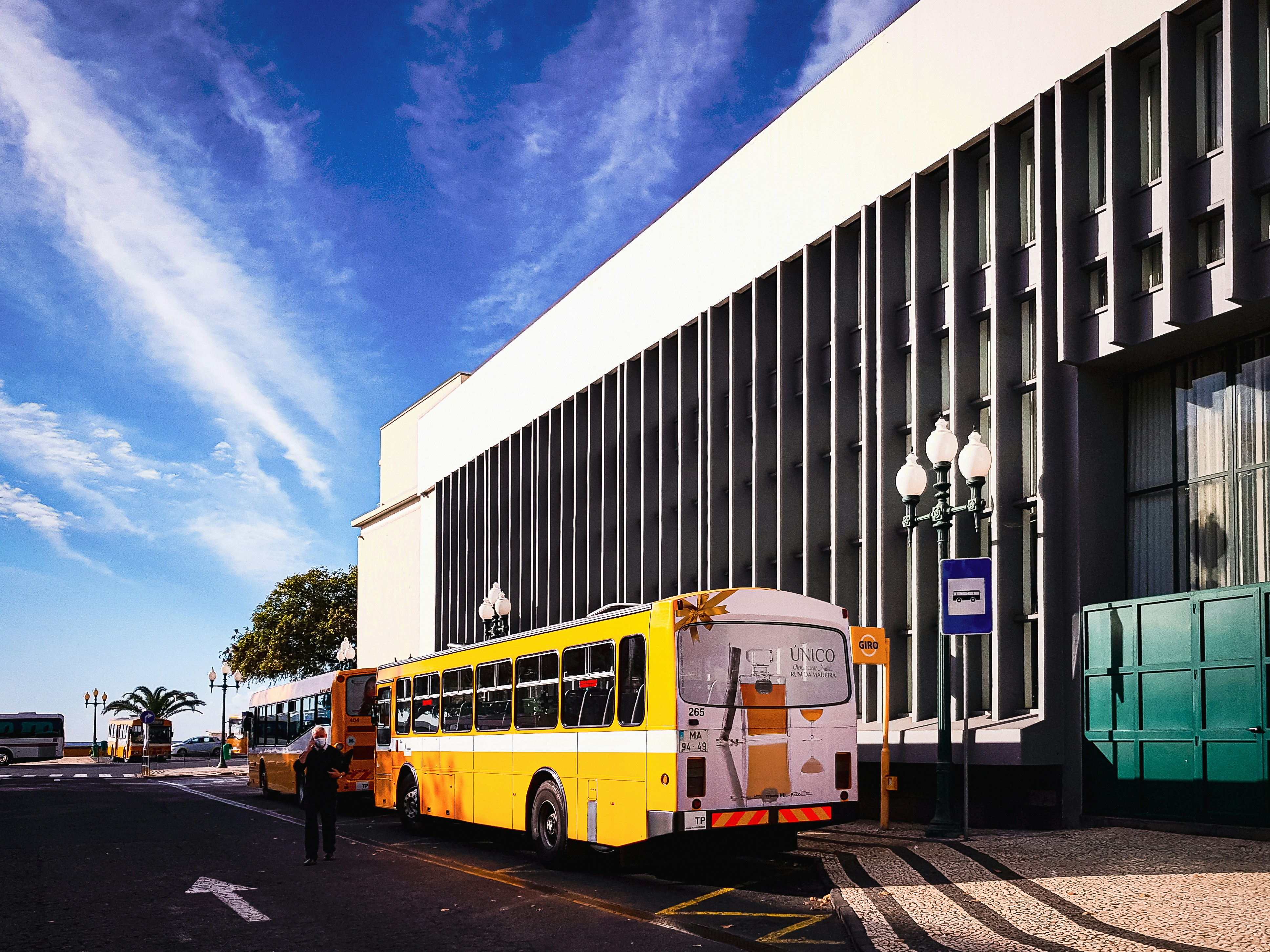 Dockside Transit: A Bold Yellow Bus Against a Striped Facade
