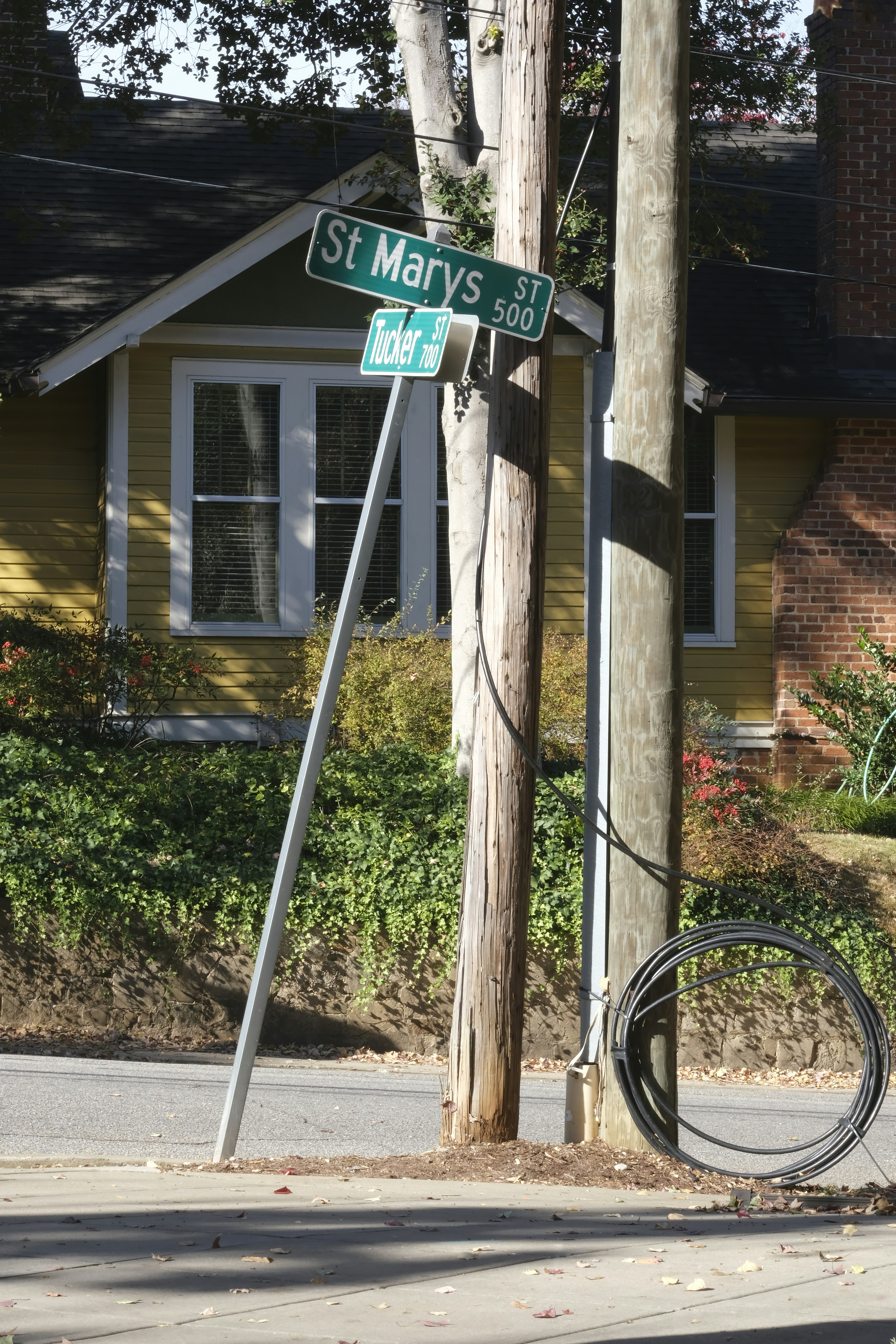 Tilted Street Sign at Tucker and St. Marys: A Quiet Corner by a Weathered Utility Pole