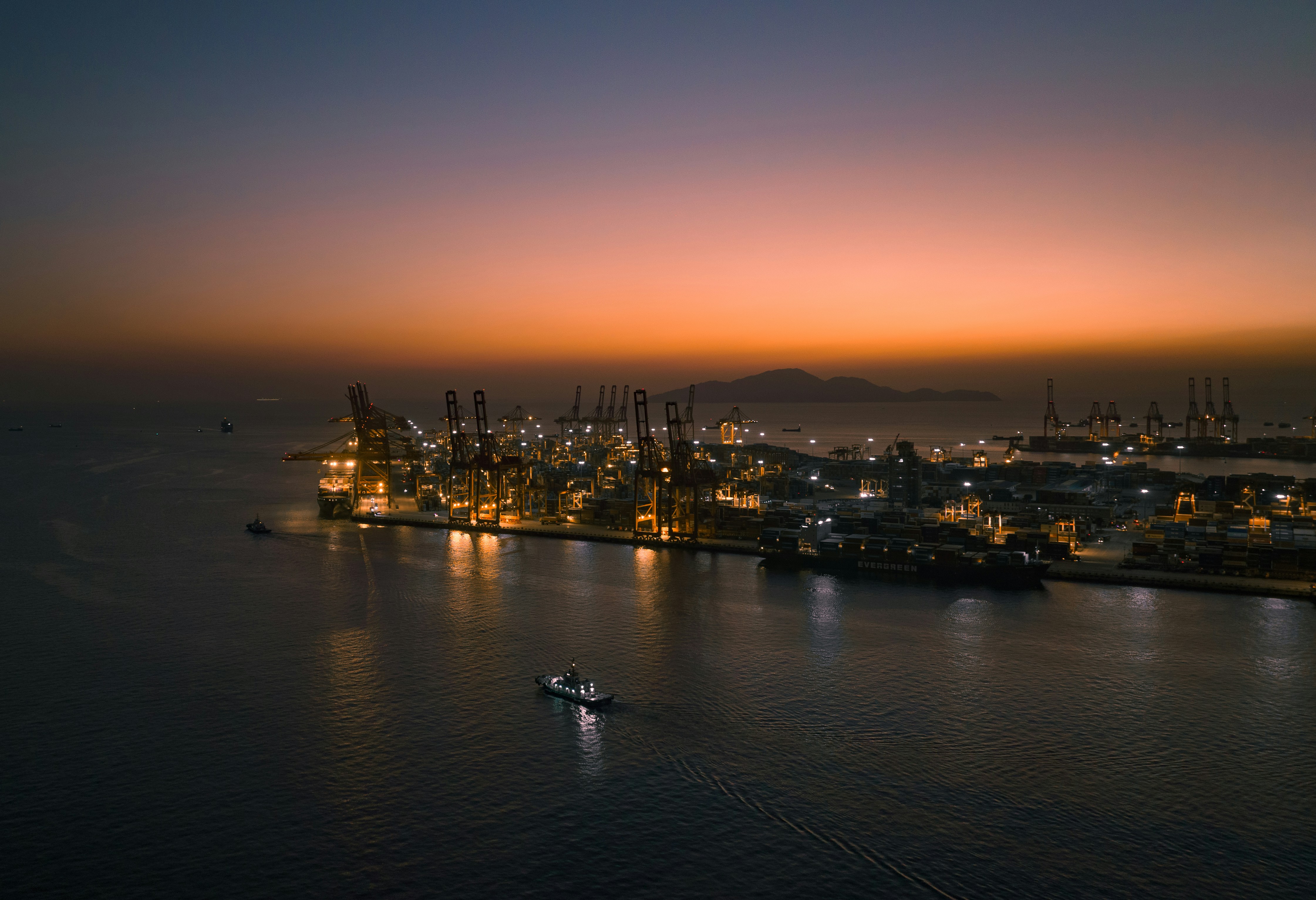 Glowing Port at Dusk: cranes and ships stitched by a horizon of fire