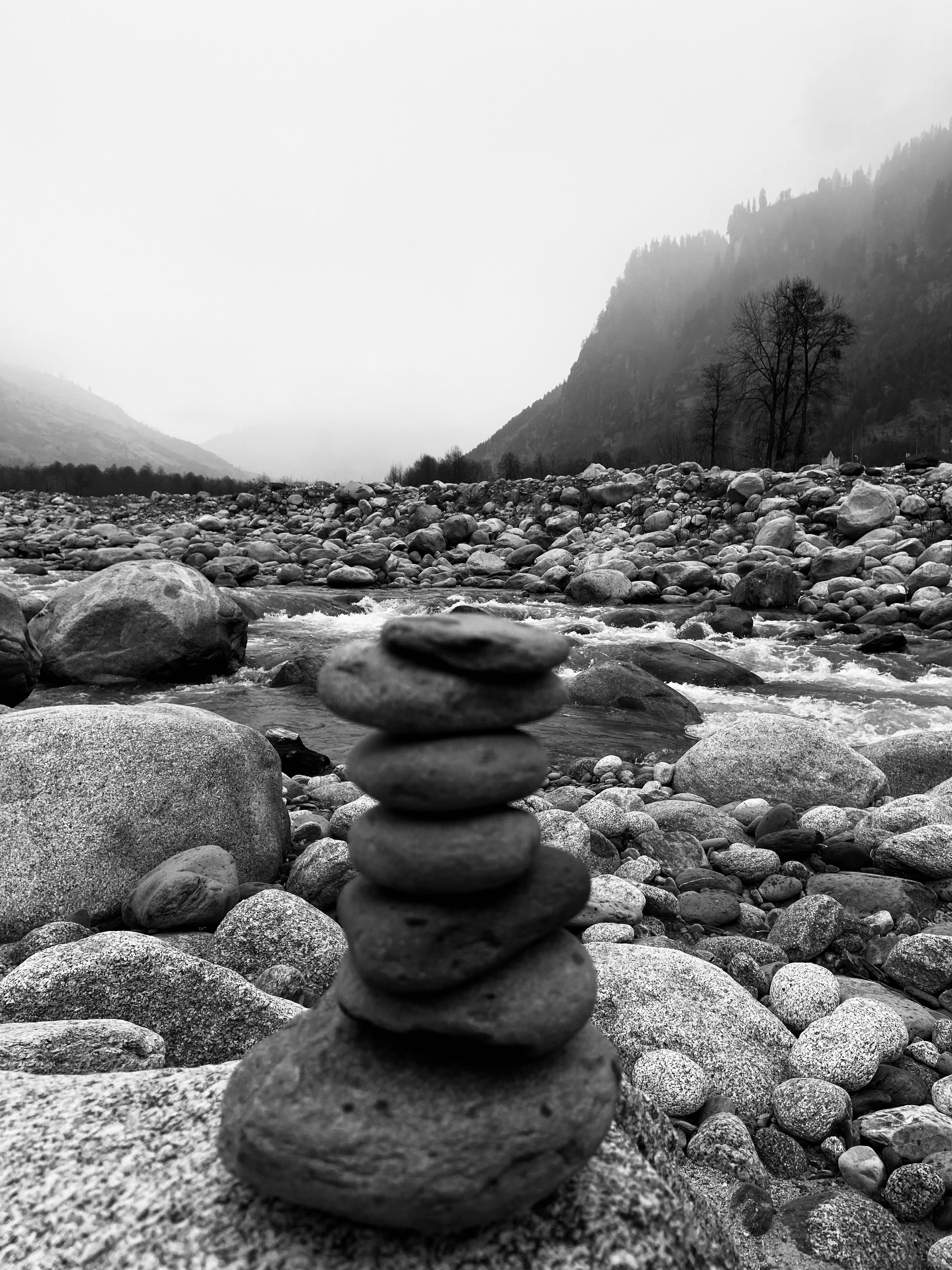 Balanced stillness: stacked stones by a riverbed