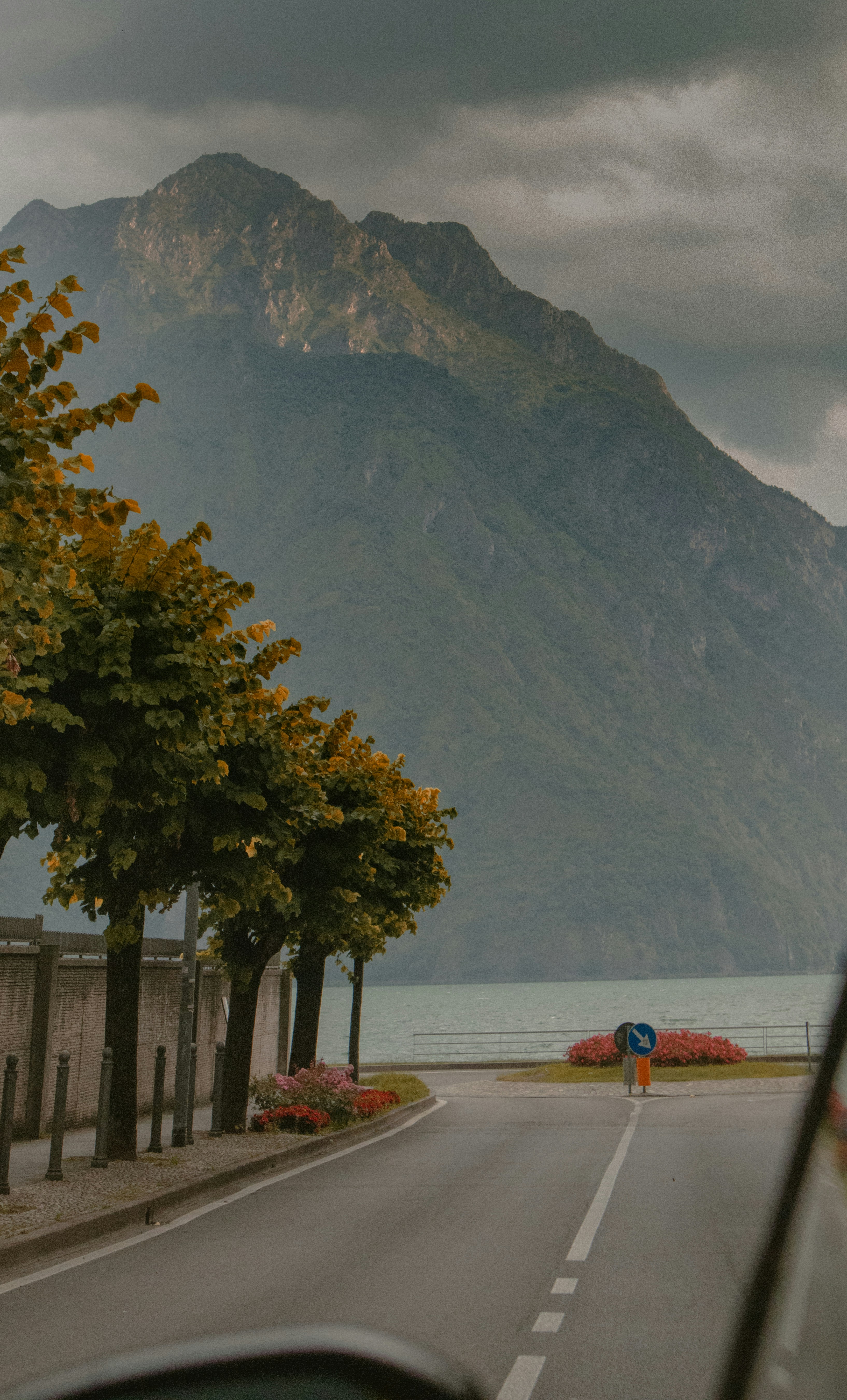 Autumn Road to the Mountain: Lakeside Drive Under Moody Skies