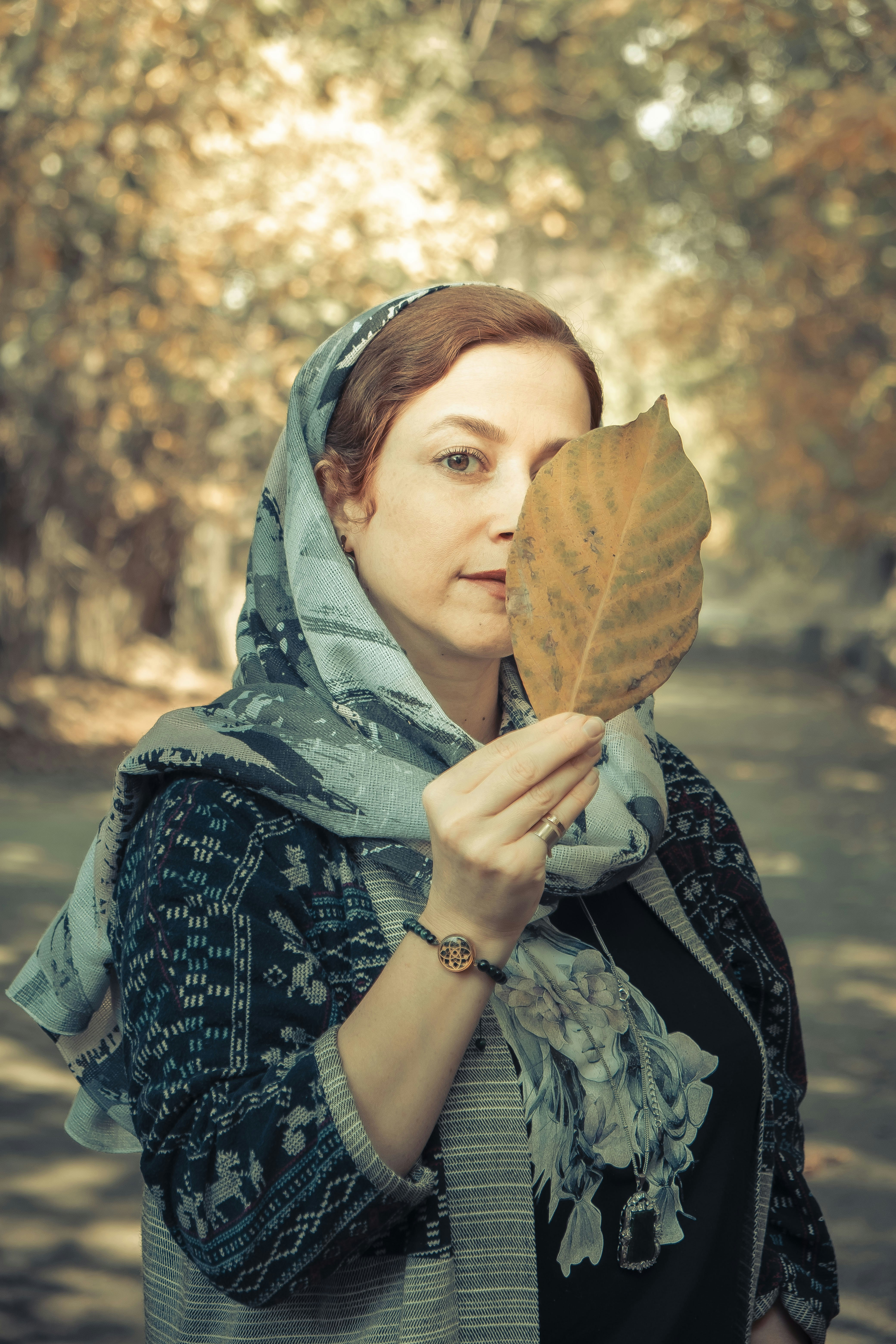 a woman holding a leaf in her hands
