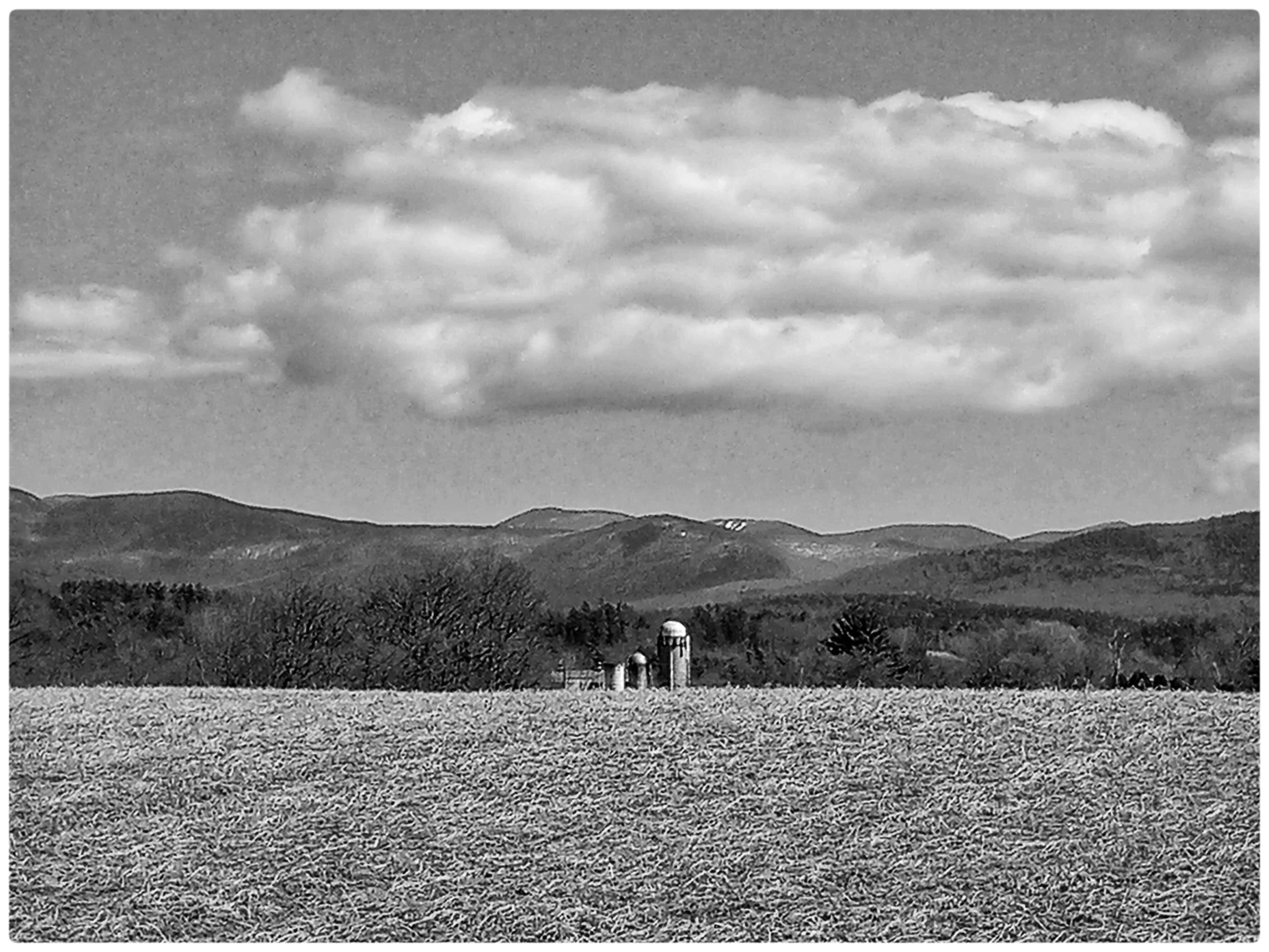 Monochrome Majesty: Silo Silhouettes Against Rolling Hills