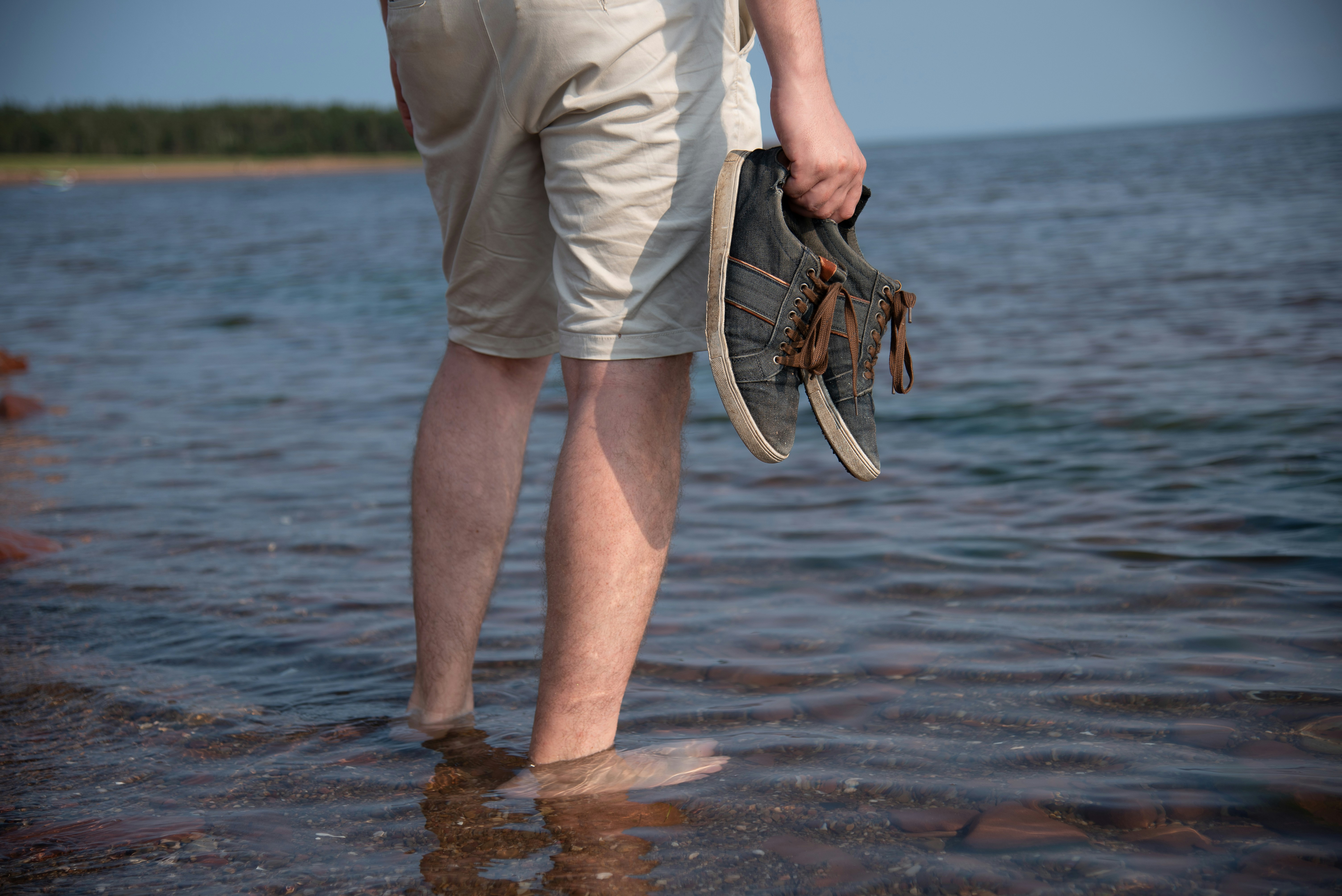 A person standing in the water with a shoe photo – Free Northumberland ...