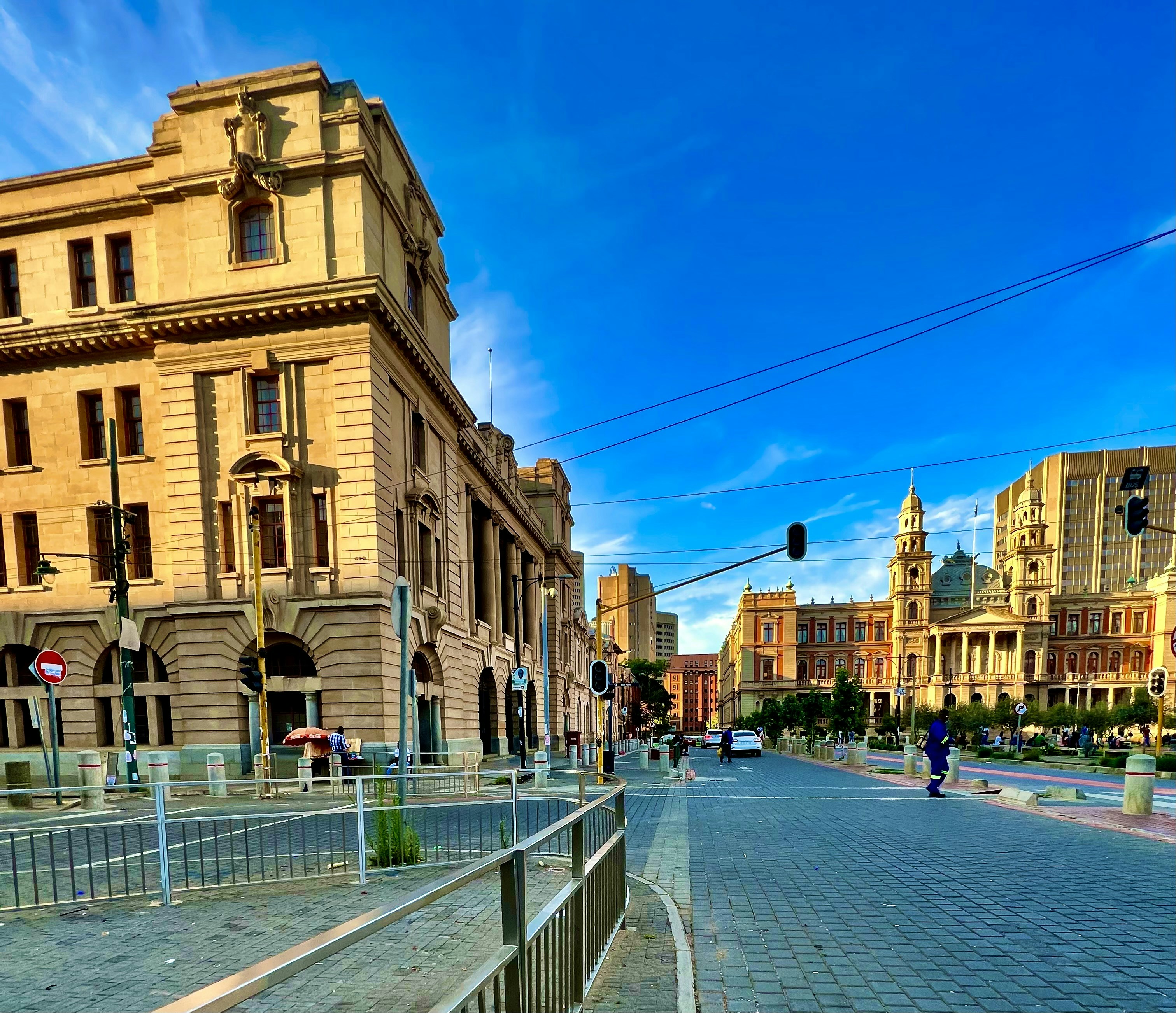 City street flanked by historic buildings under a vibrant blue sky.