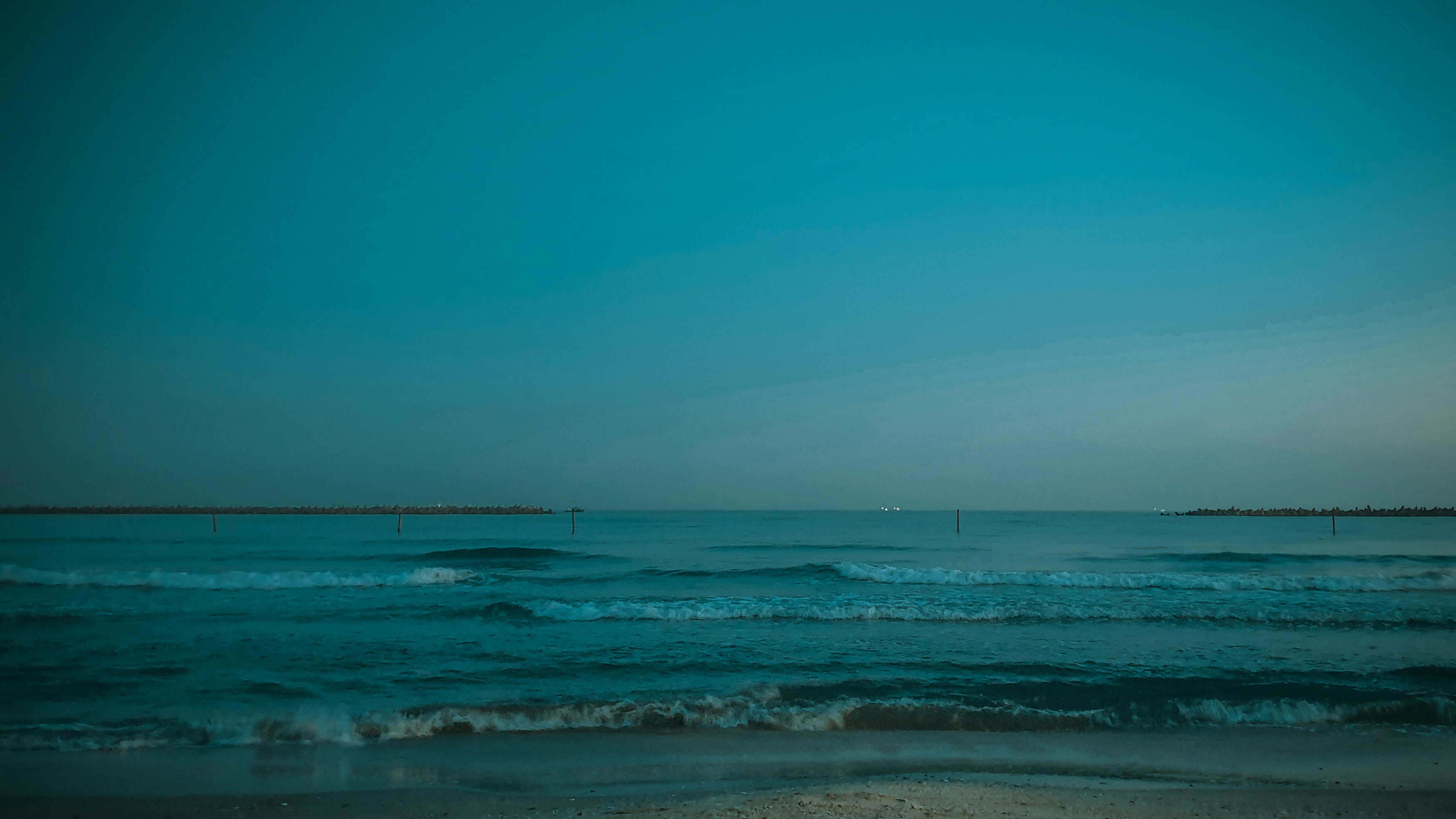 Un cuerpo de agua con olas que llegan a la orilla foto – Imagen de Ras ...