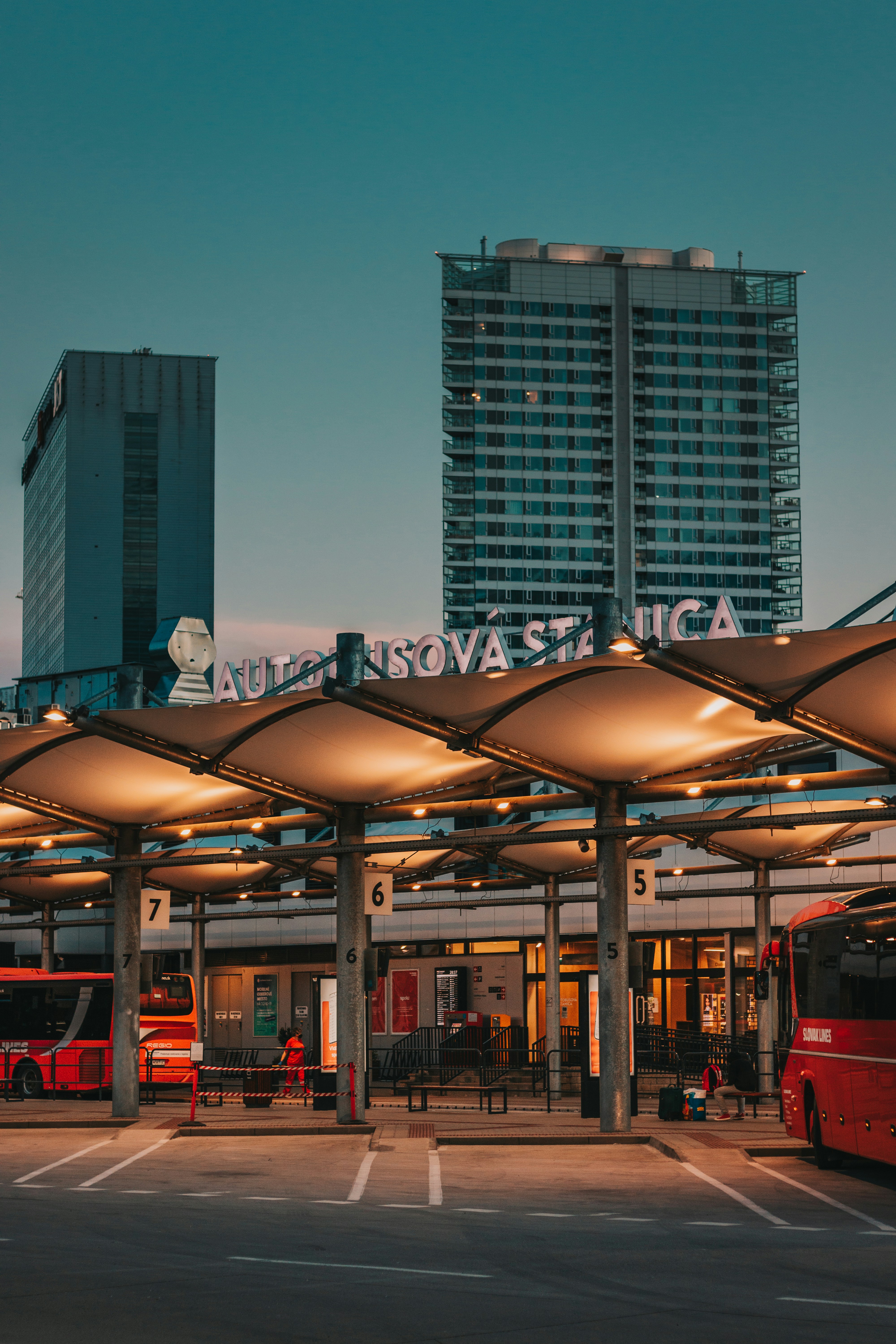 A red bus parked in front of a bus station photo – Free Bus Image on ...