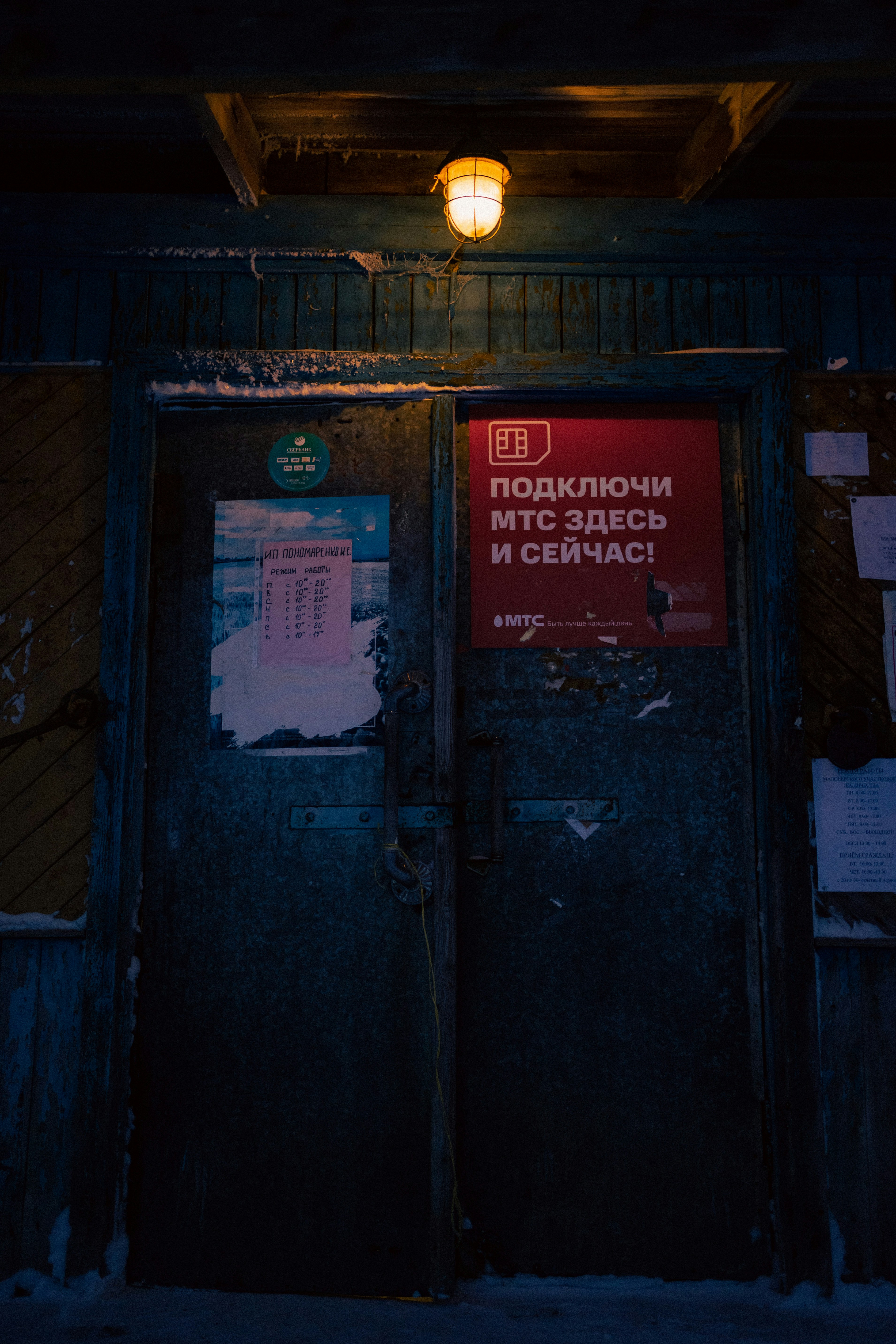 A dark room with two doors and a sign on the door photo – Free Door ...